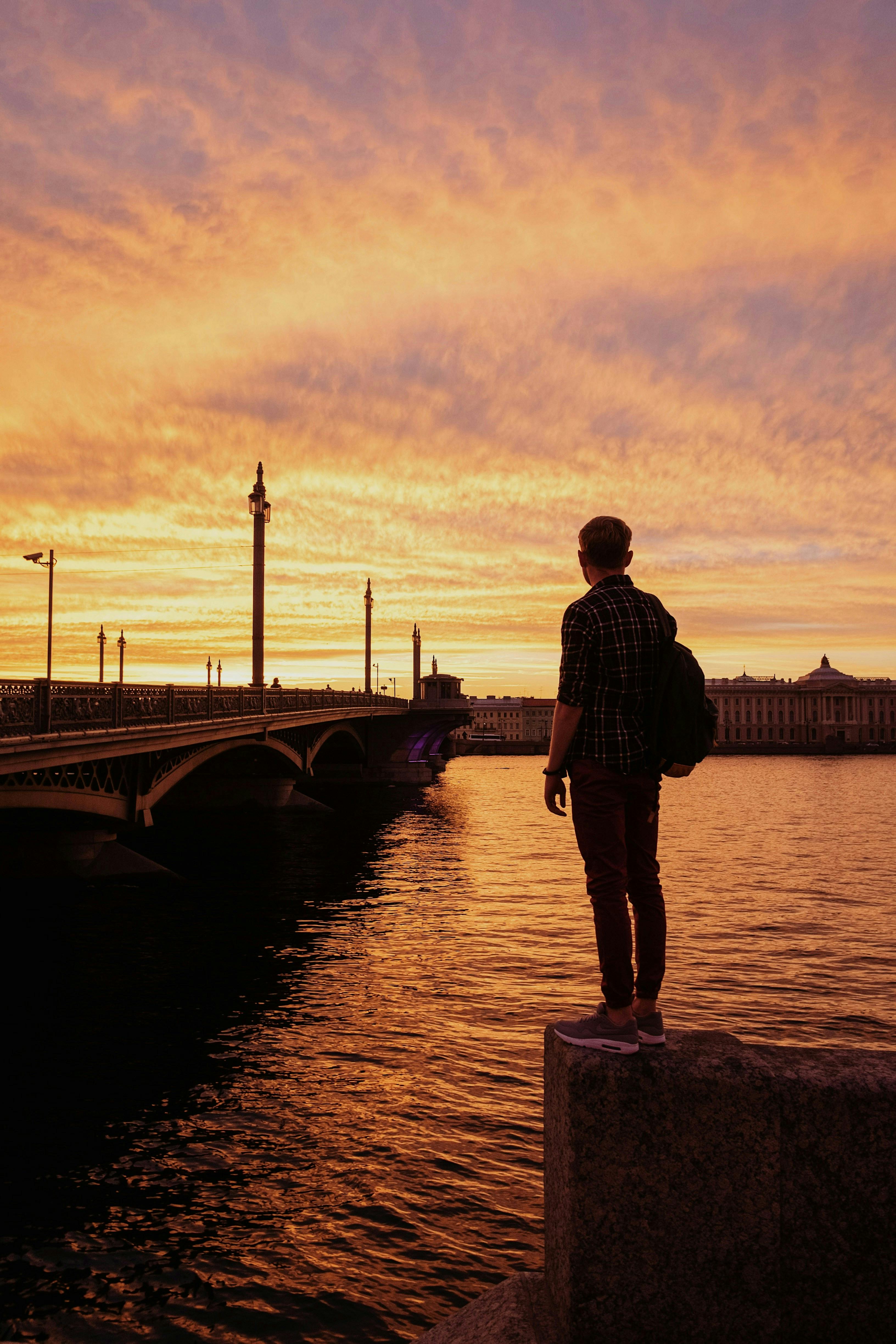 Man Standing by River and Looking at Bridge in City · Free Stock Photo