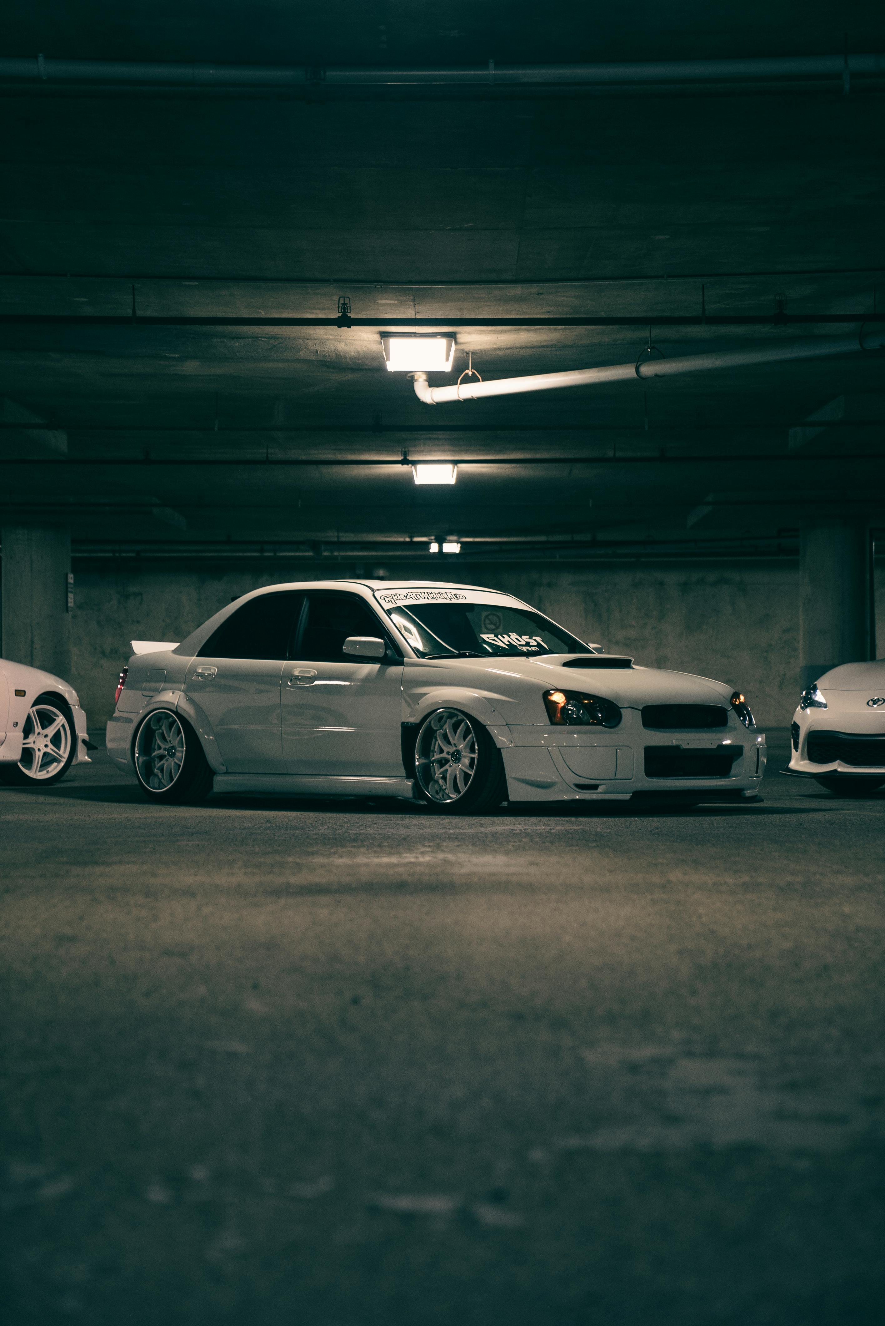 Two white cars parked in a garage · Free Stock Photo