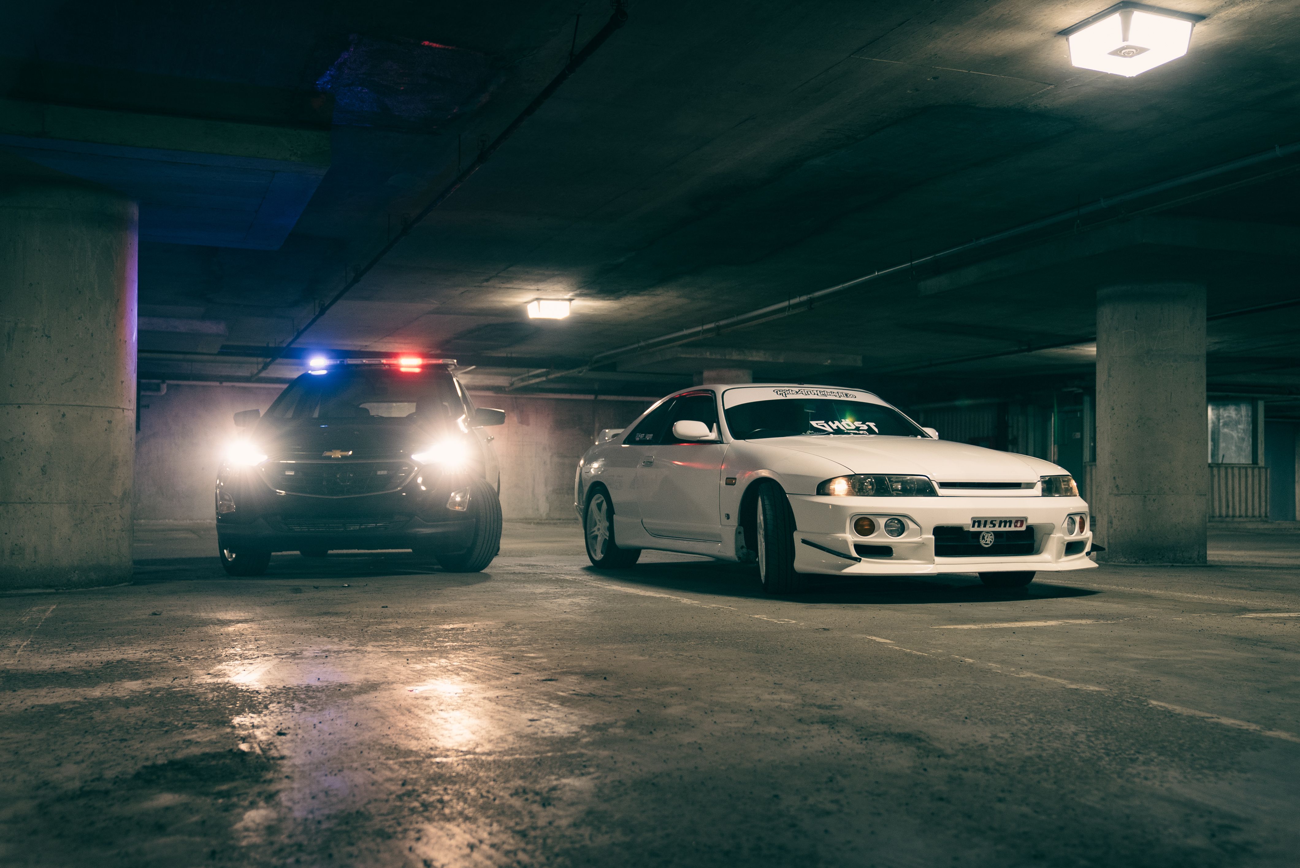 Two police cars parked in a parking garage · Free Stock Photo