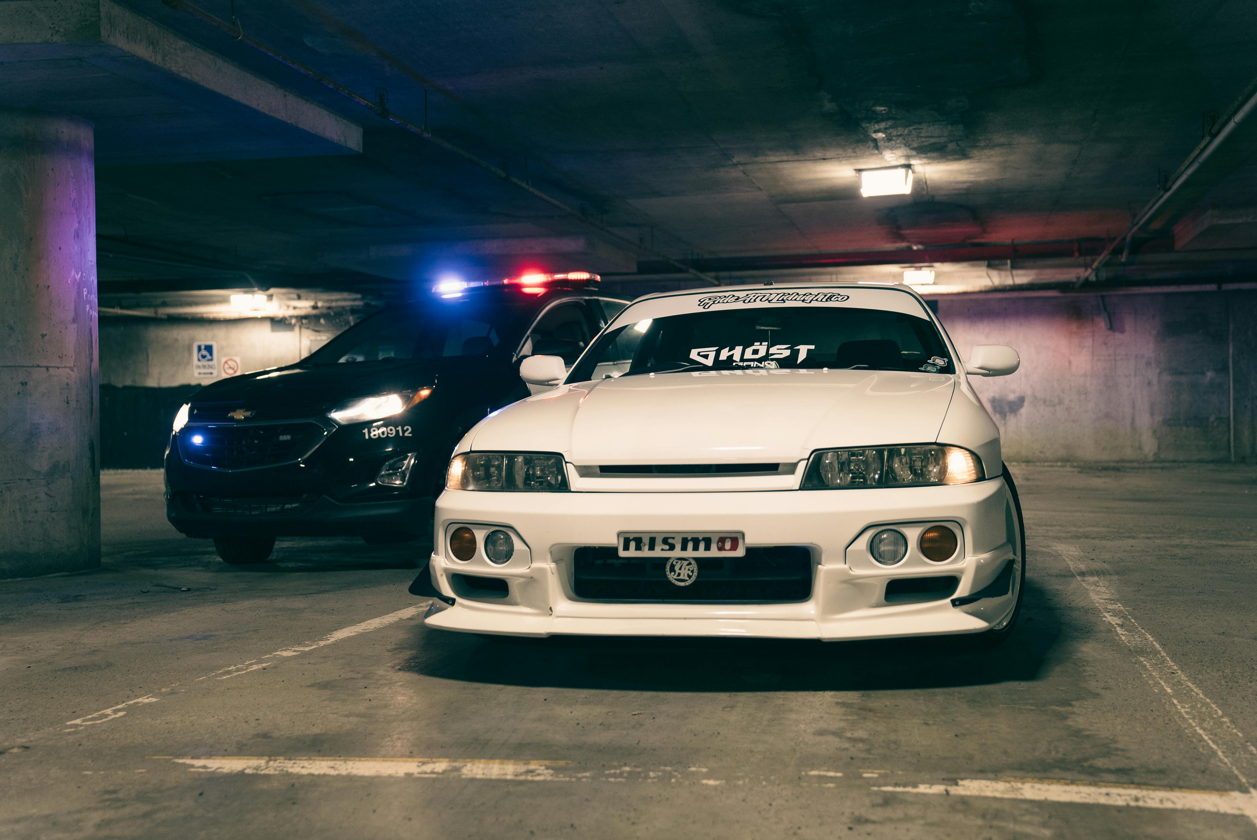 Two police cars parked in a parking garage · Free Stock Photo