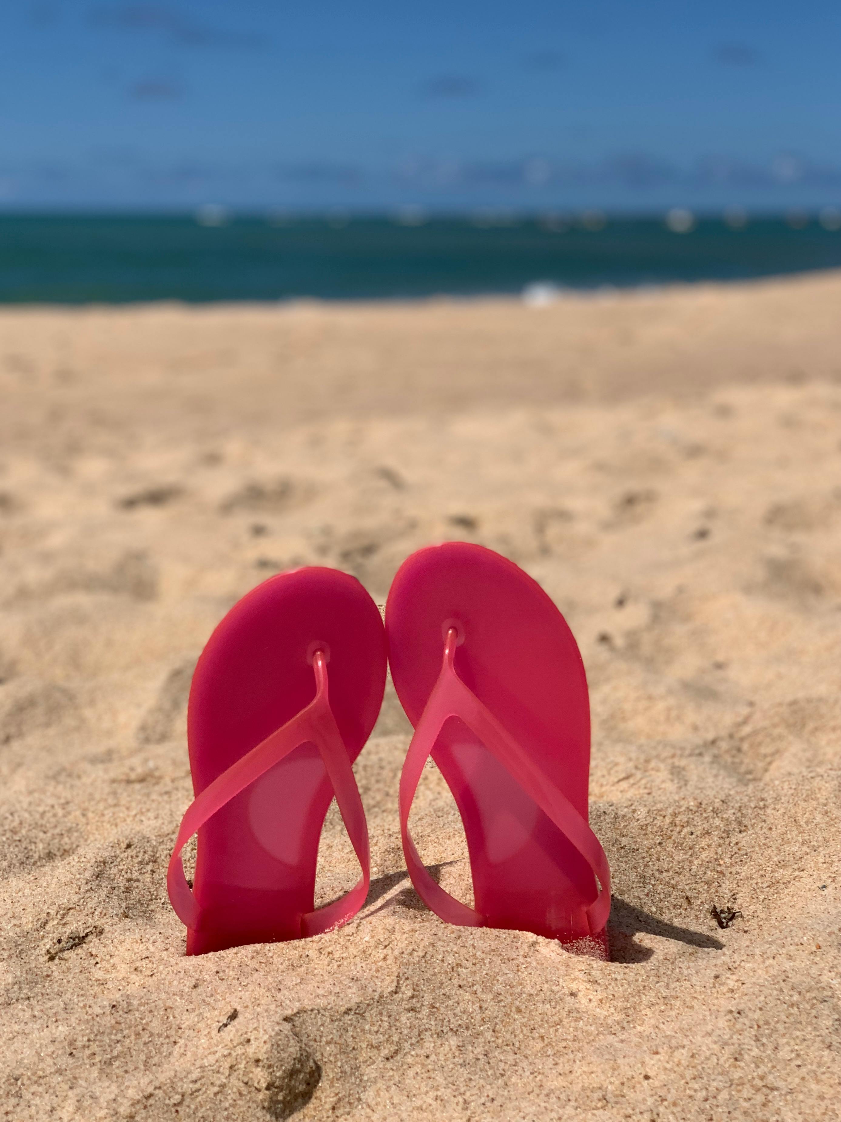 Foto De Vista Superior De Chinelos Na Praia · Foto profissional gratuita