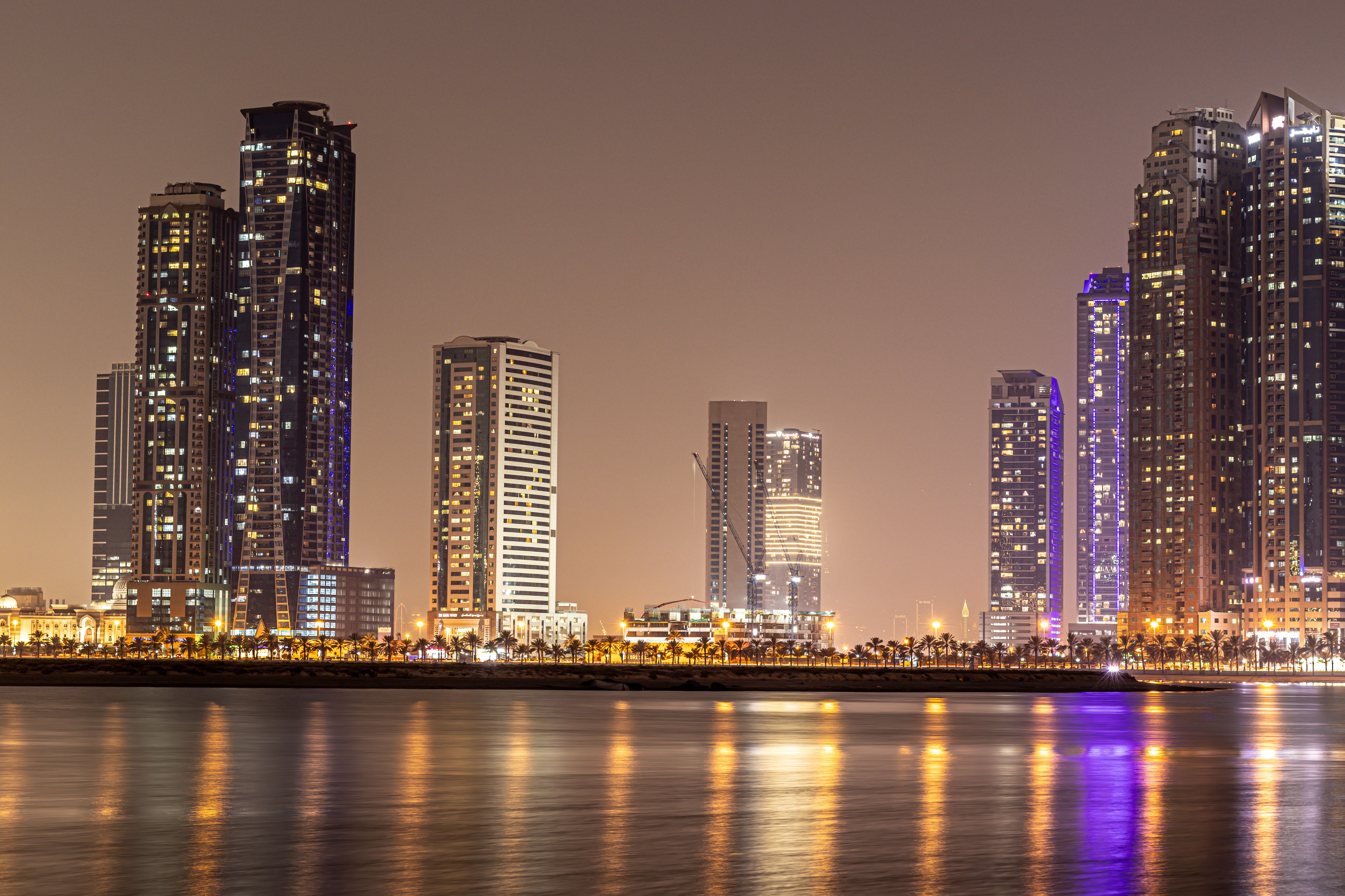 A city skyline at night with lights reflecting in the water · Free ...