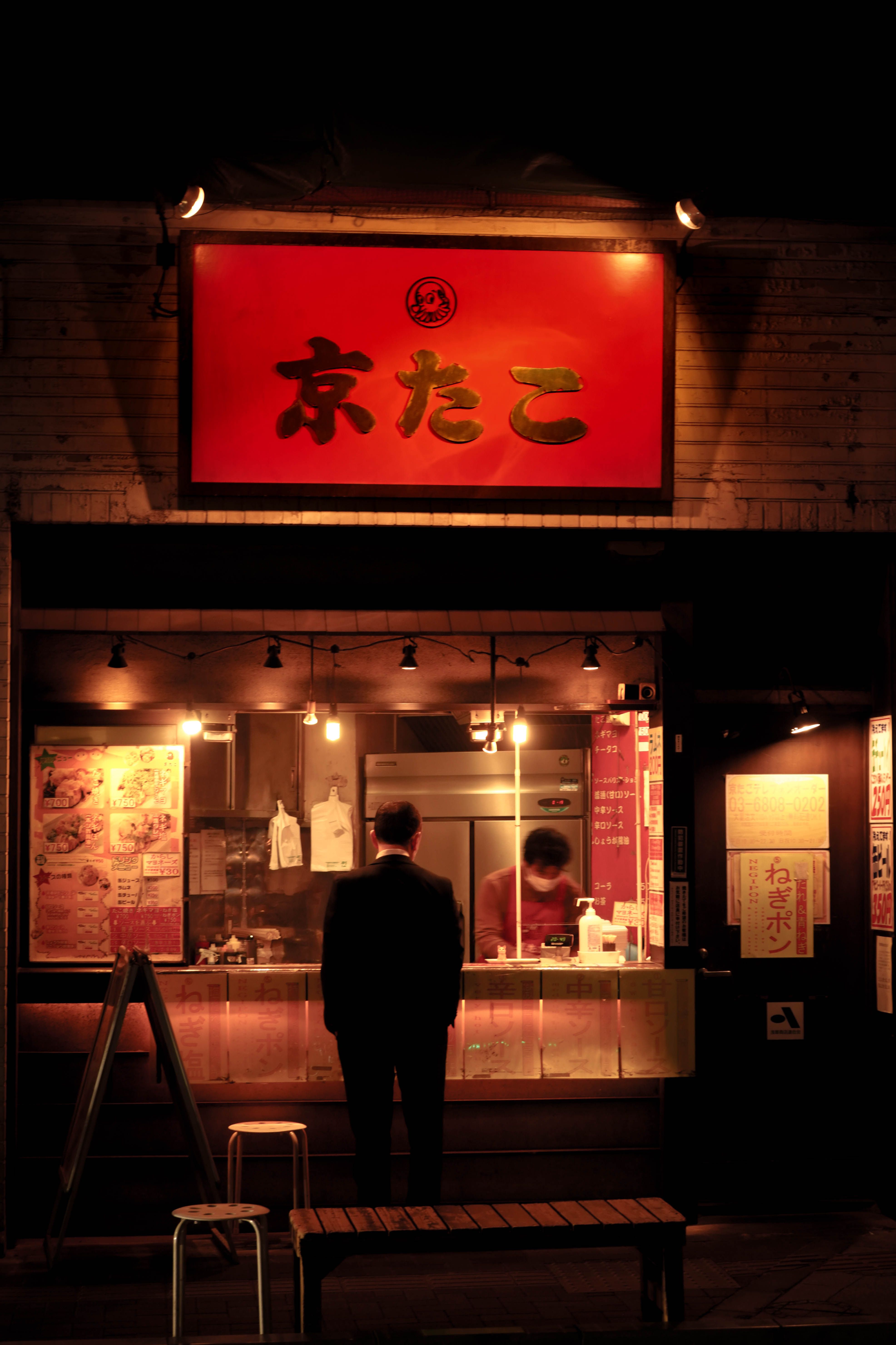 A man standing in front of a japanese restaurant · Free Stock Photo
