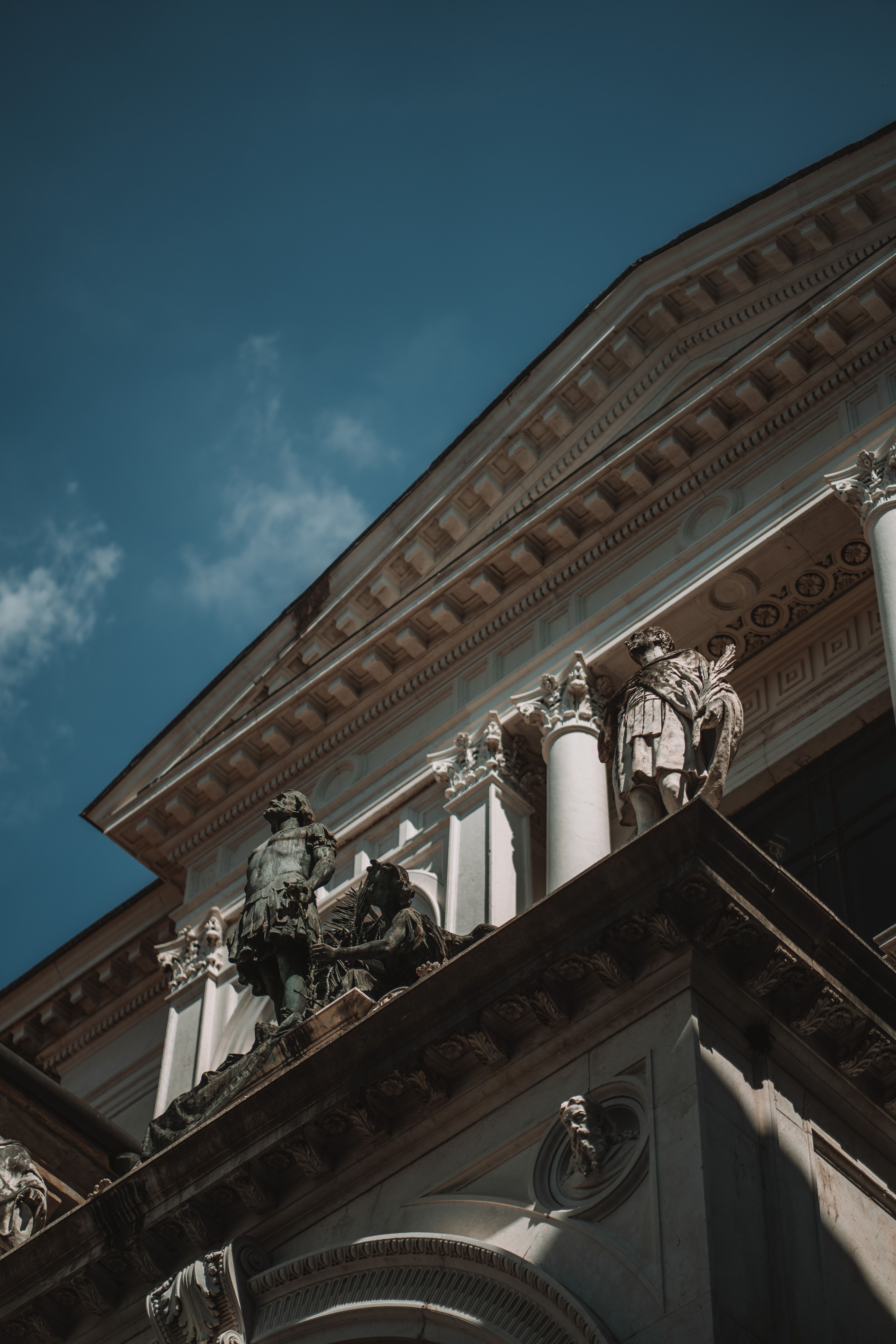 A statue on top of a building with a blue sky · Free Stock Photo