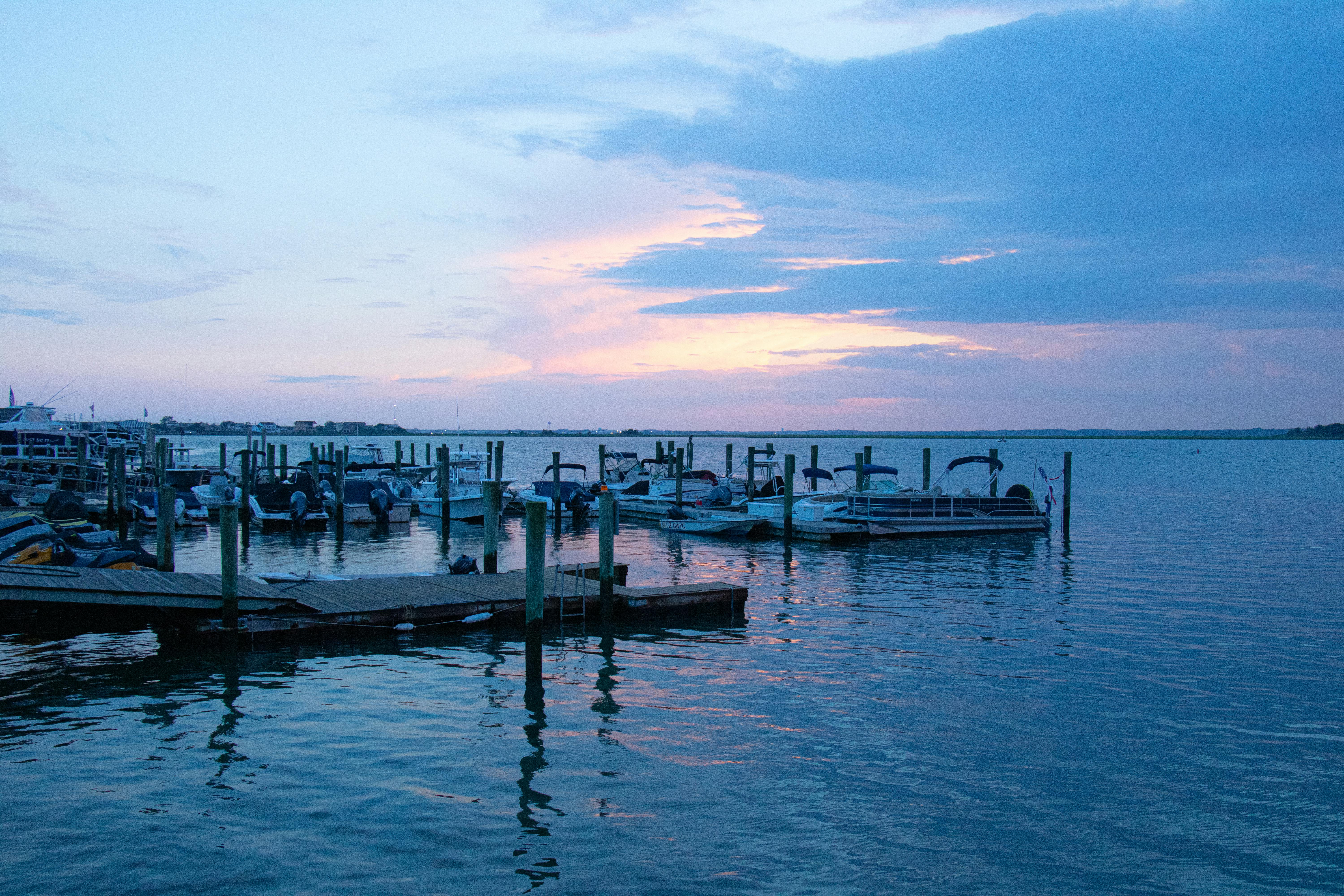 A dock with boats docked at sunset · Free Stock Photo