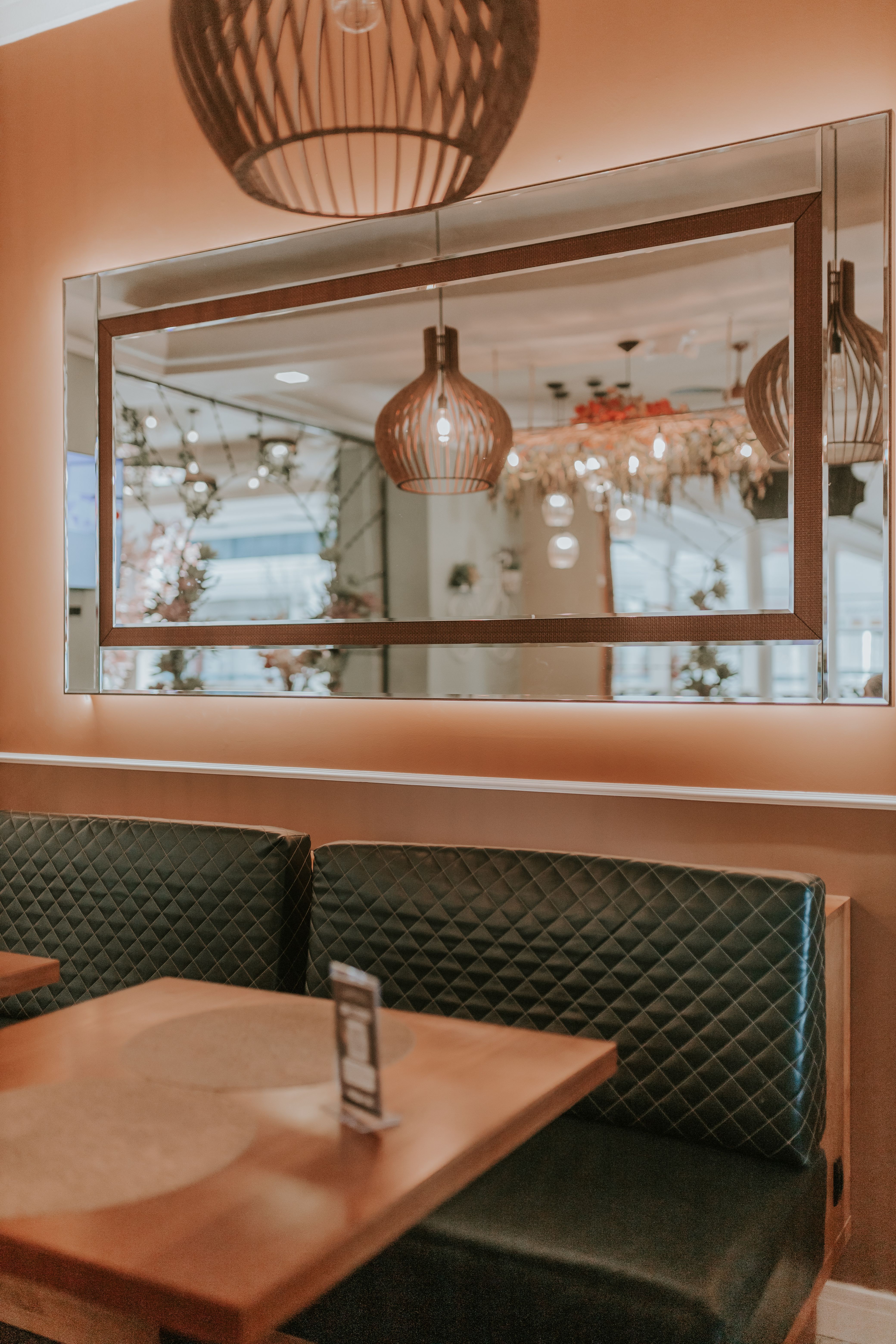 A restaurant with a large mirror above the table · Free Stock Photo
