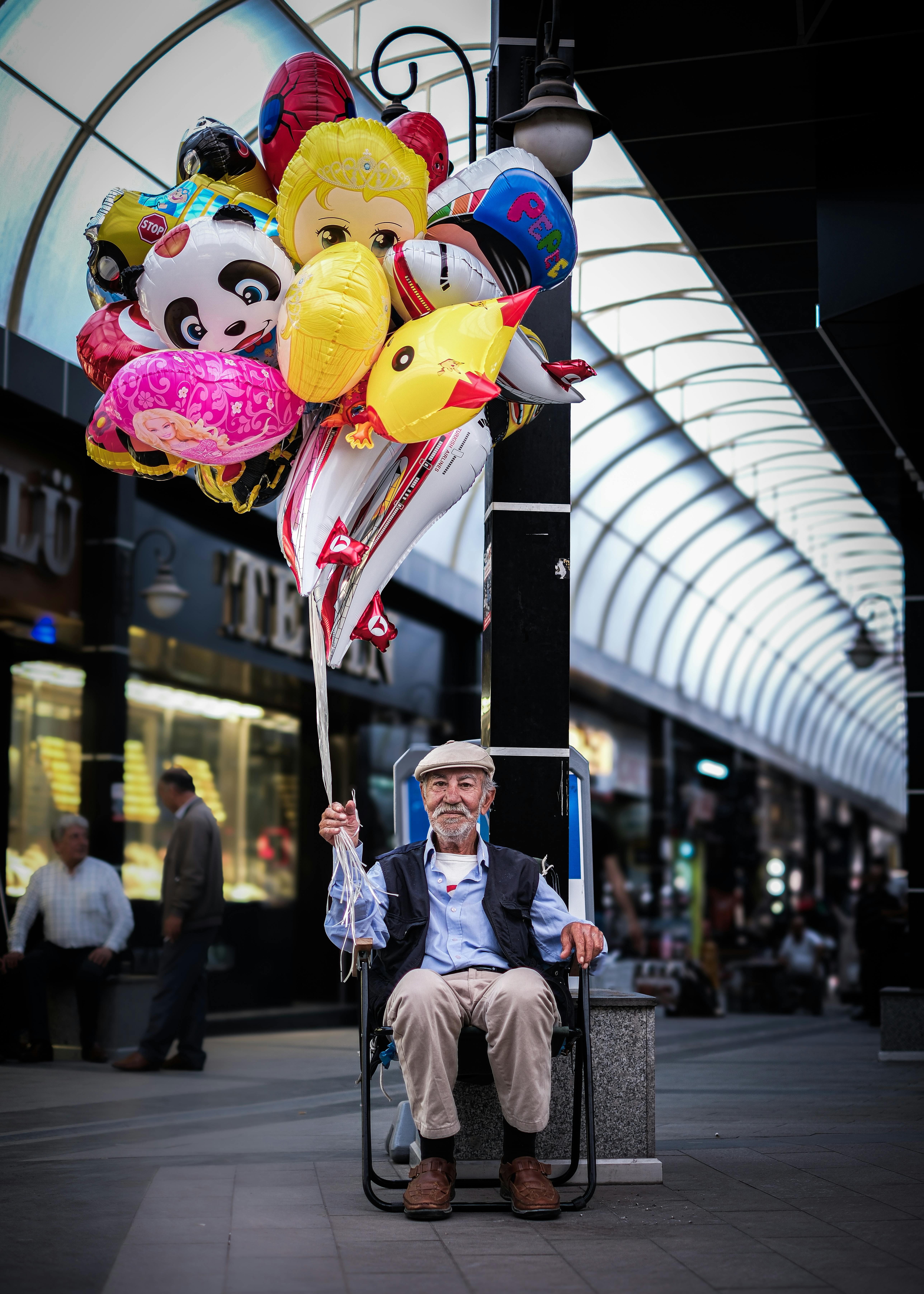 A man sitting in a chair with balloons and stuffed animals · Free Stock ...