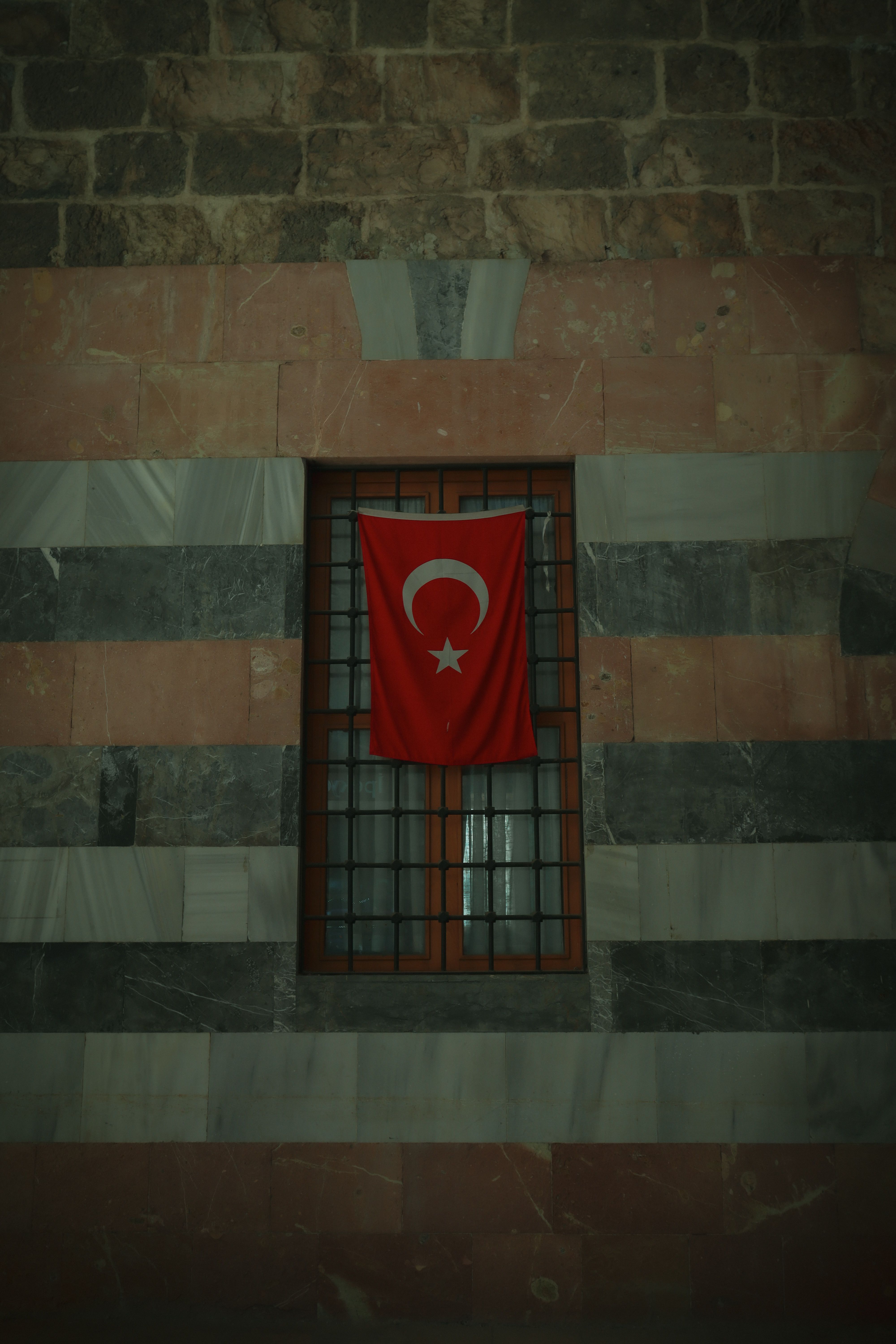 A flag is hanging from a window in a building · Free Stock Photo
