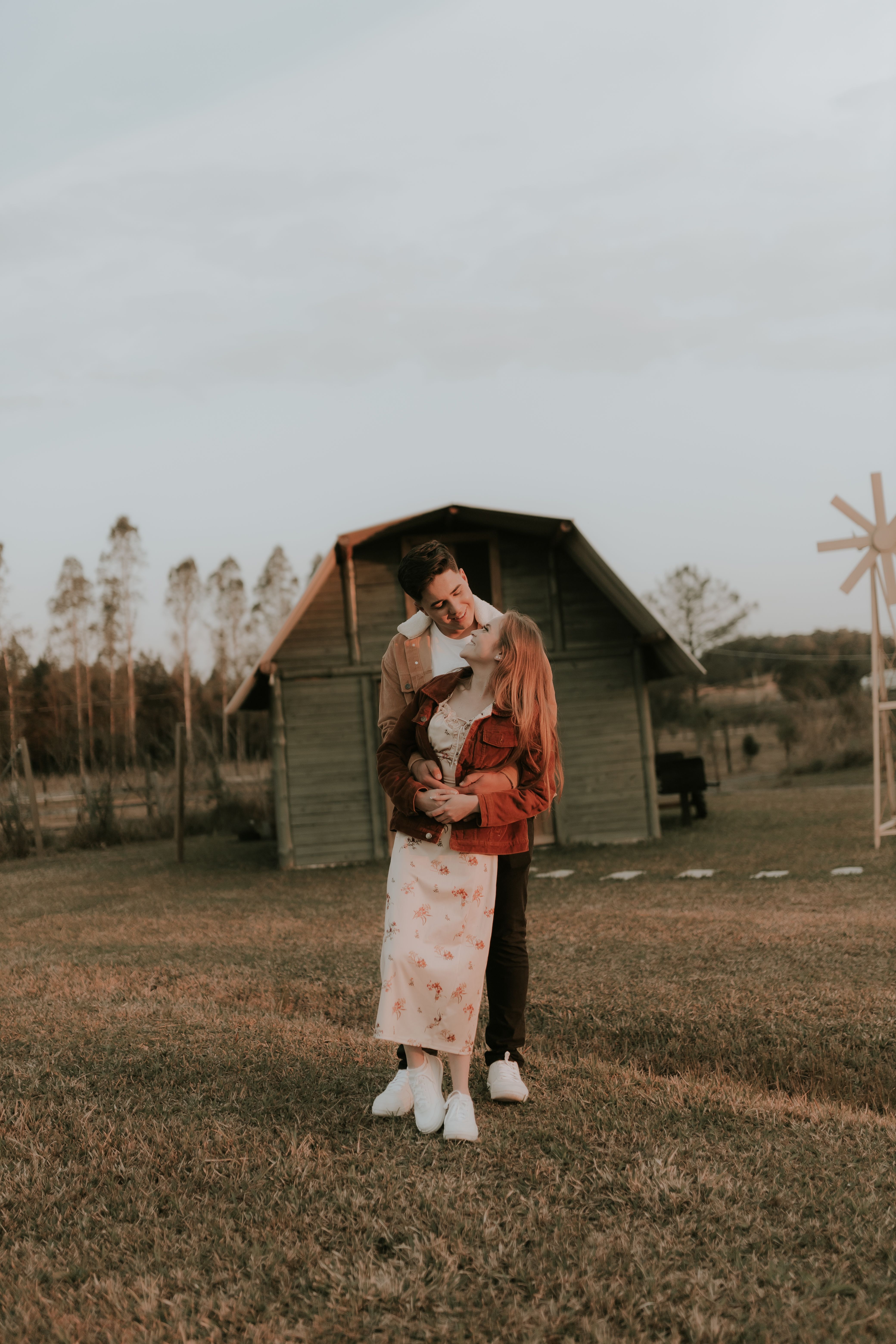 A couple is standing in front of a barn · Free Stock Photo