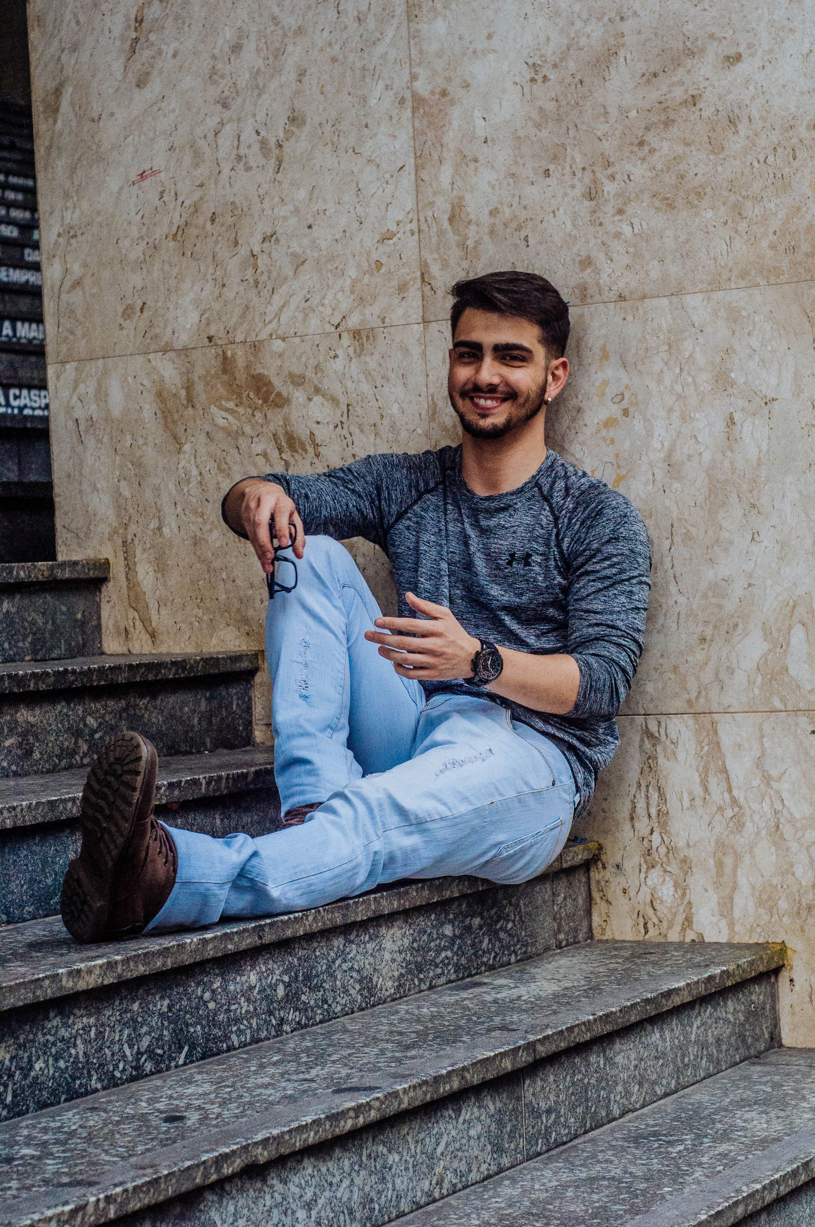 A man sitting on some steps with a smile · Free Stock Photo