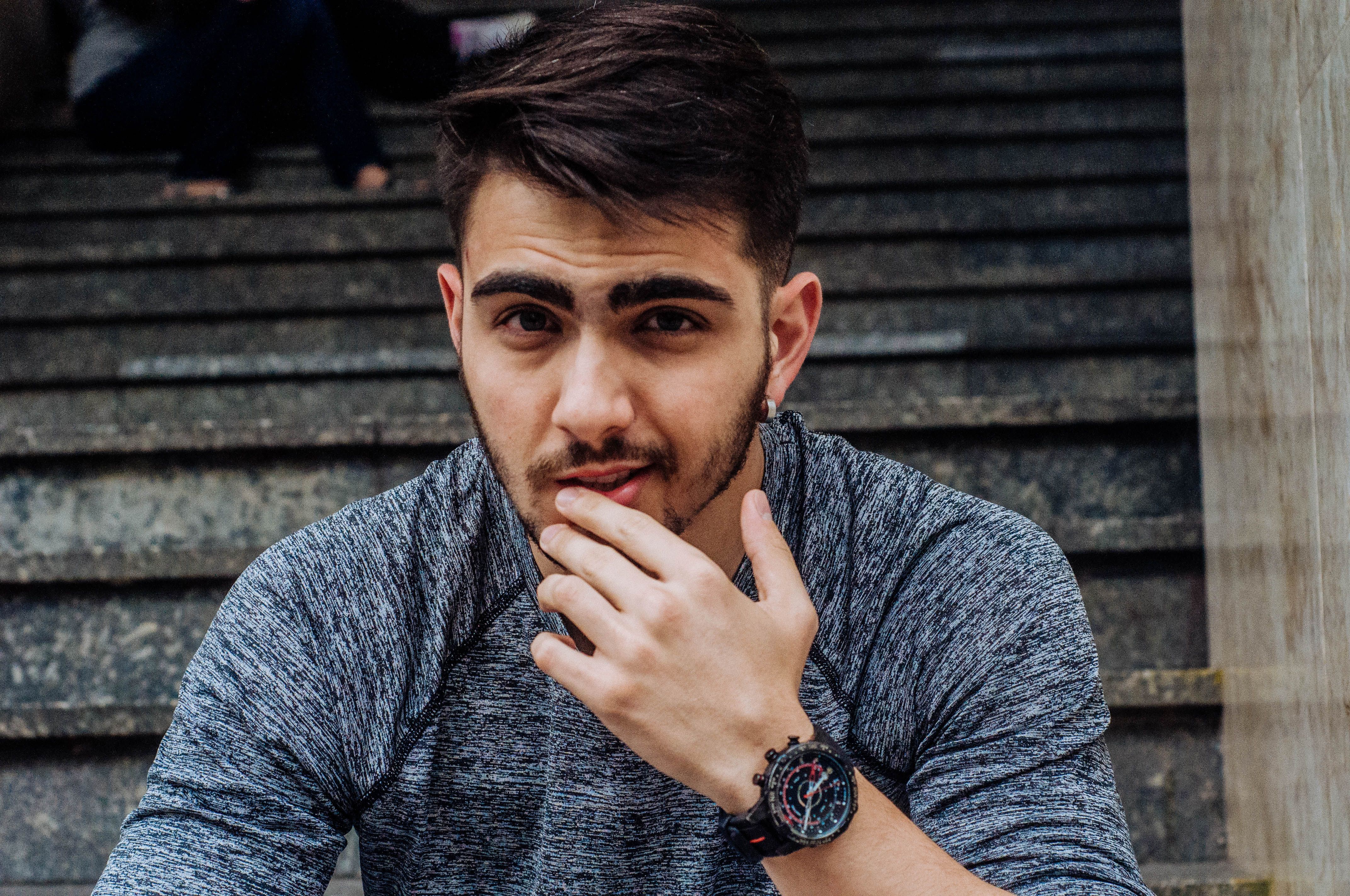 A man with a watch on his hand sitting on steps · Free Stock Photo
