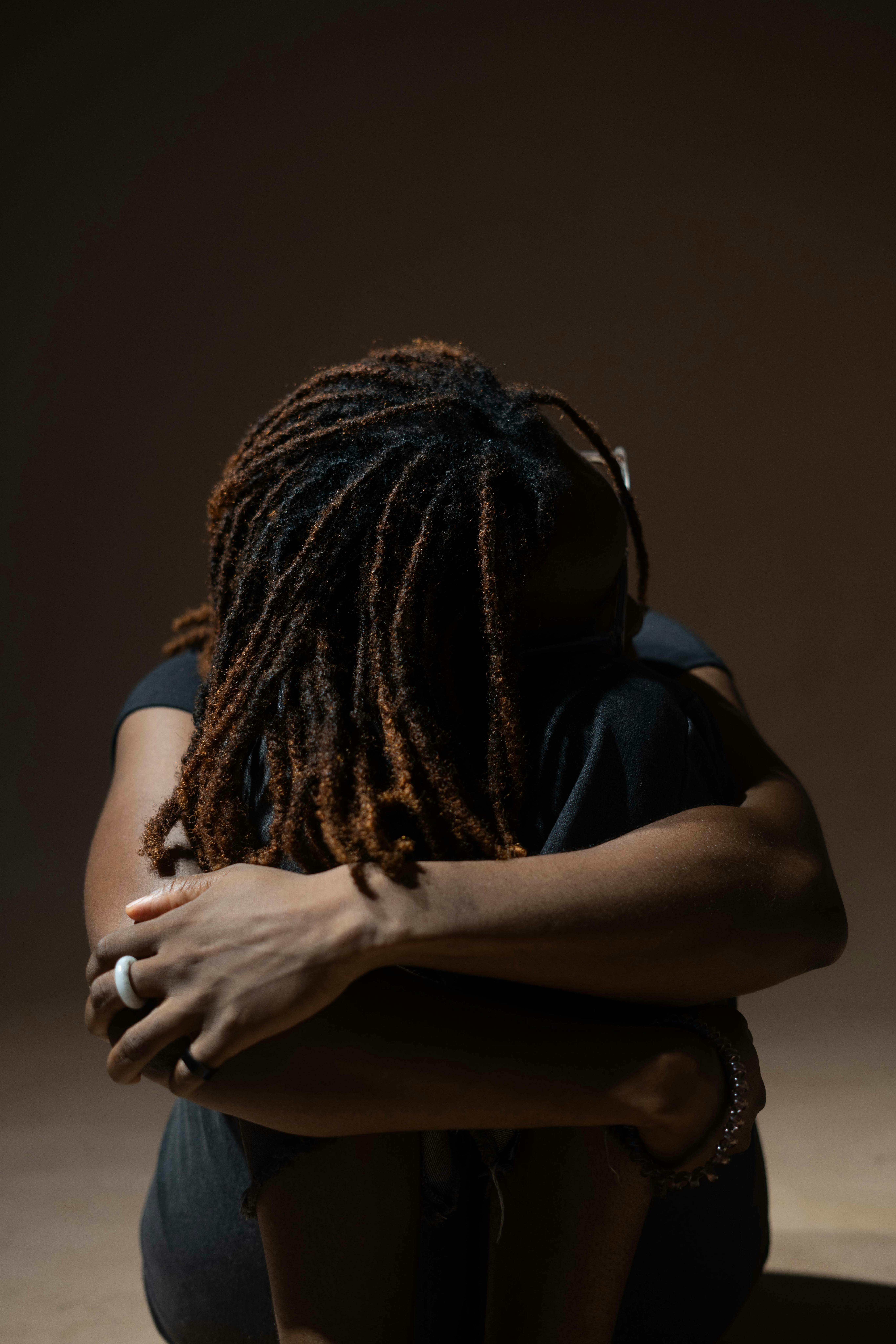 A woman with dreadlocks sitting on the ground · Free Stock Photo