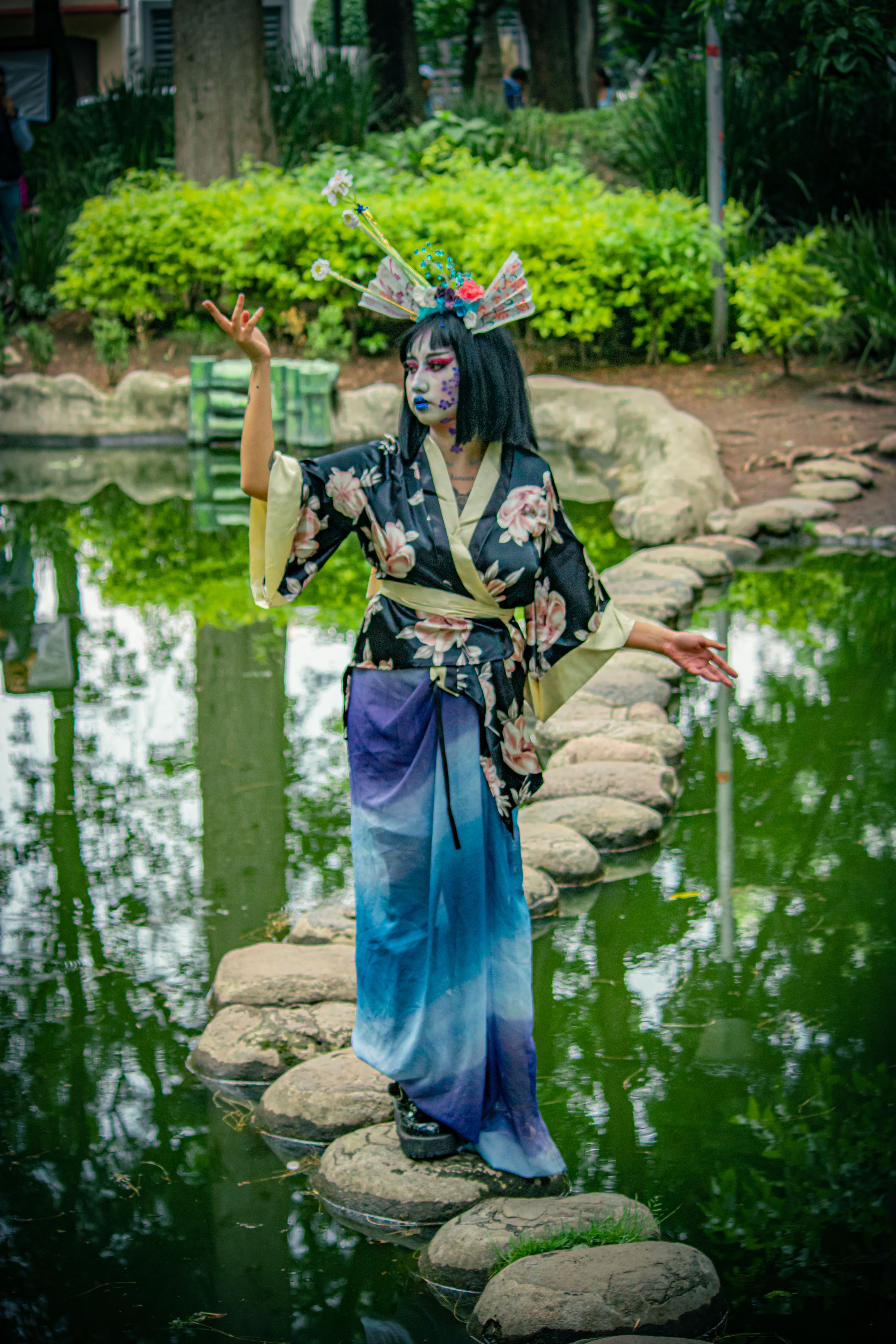 A woman in a geisha costume is standing on a bridge · Free Stock Photo