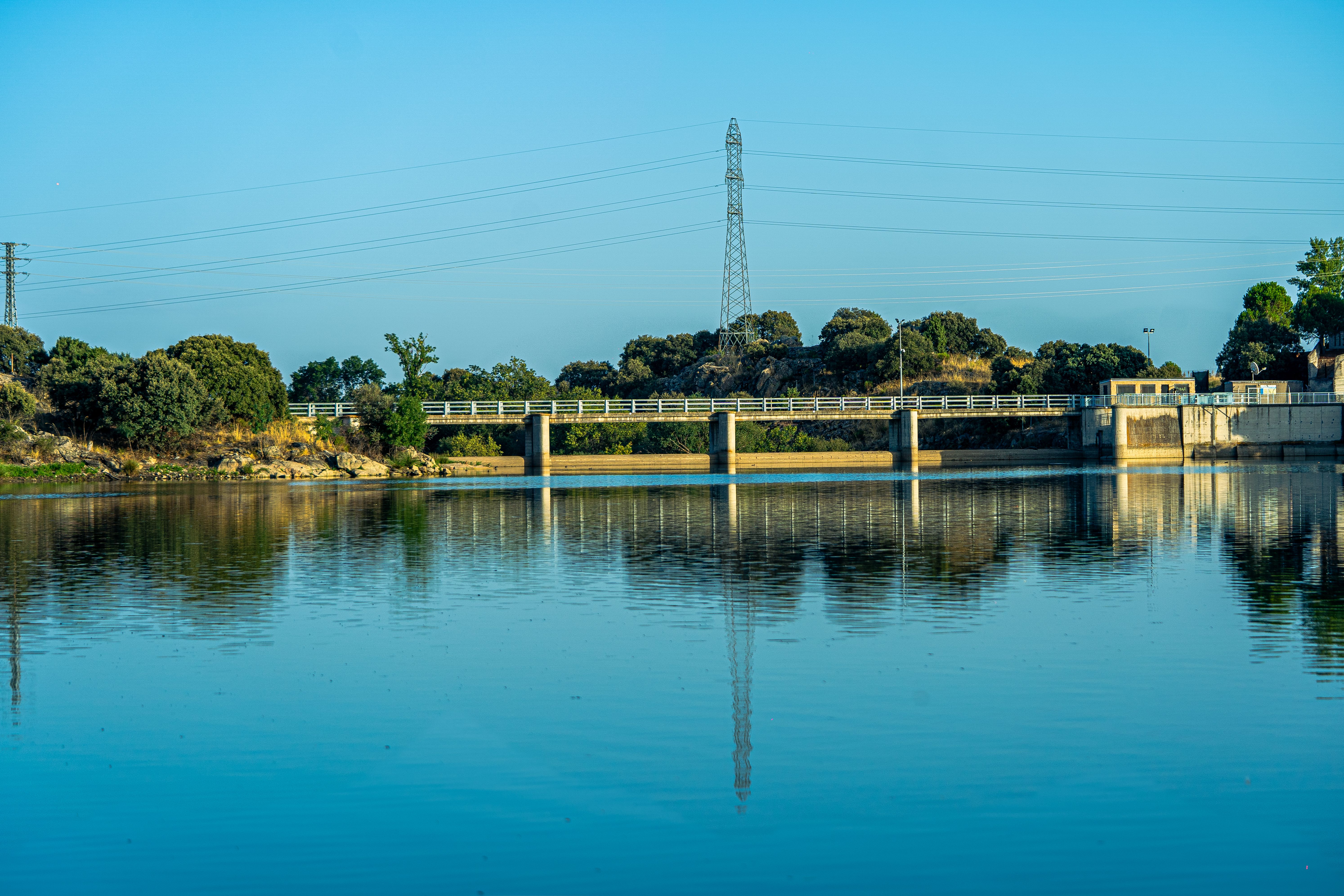 A bridge over a body of water with a power line · Free Stock Photo