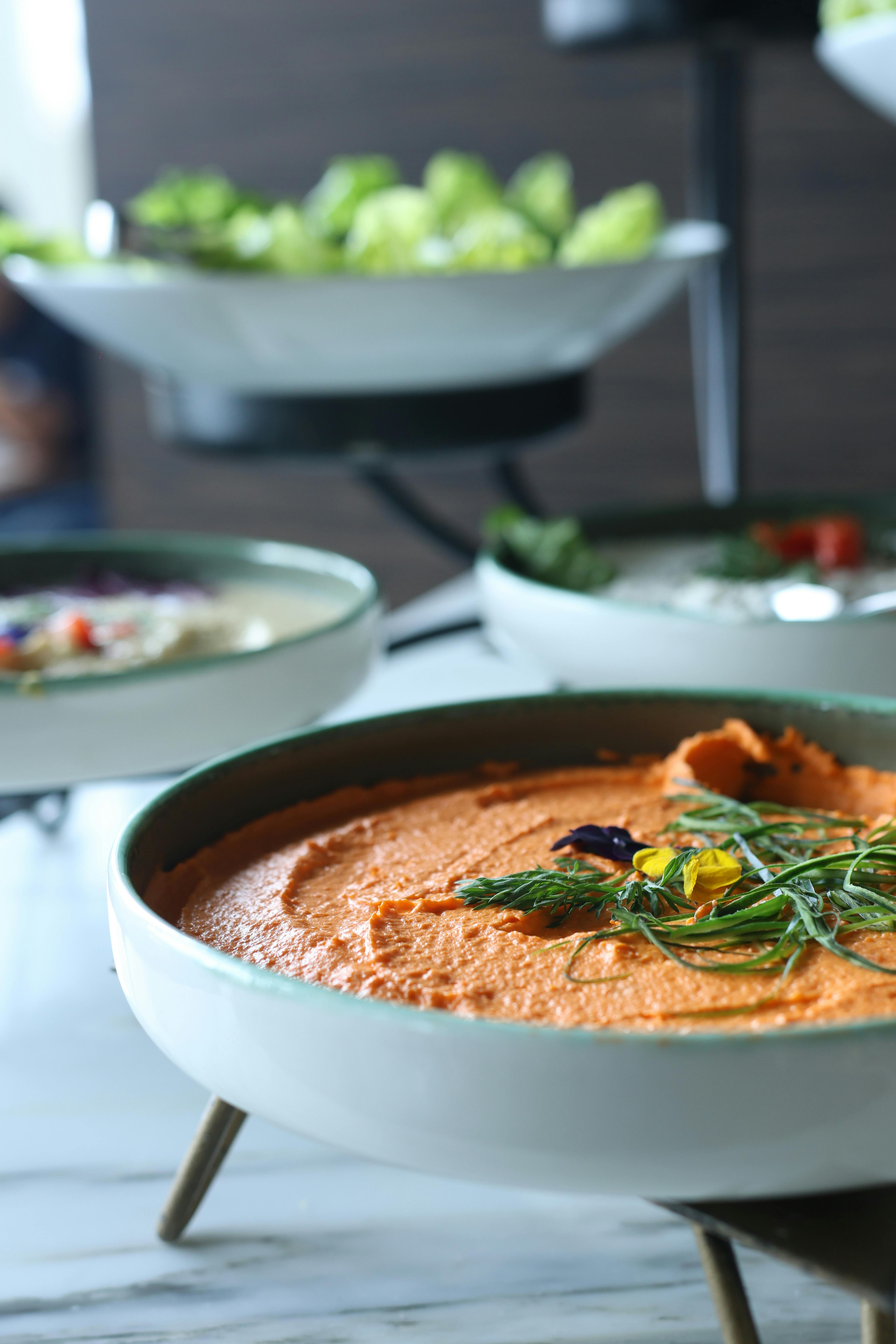 A buffet of food with bowls of soup and vegetables · Free Stock Photo