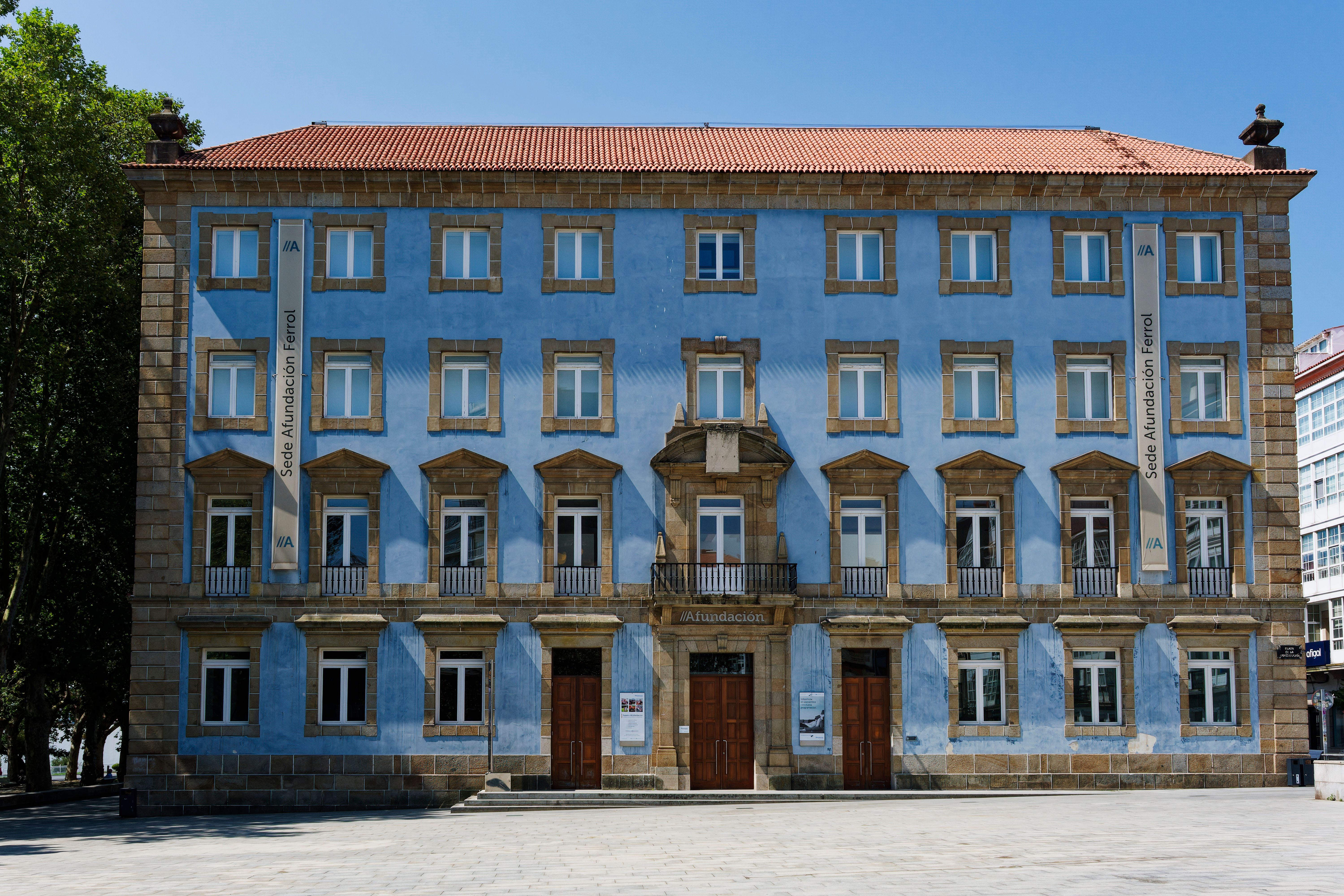 Historic blue building in a sunny plaza, showcasing classic ...