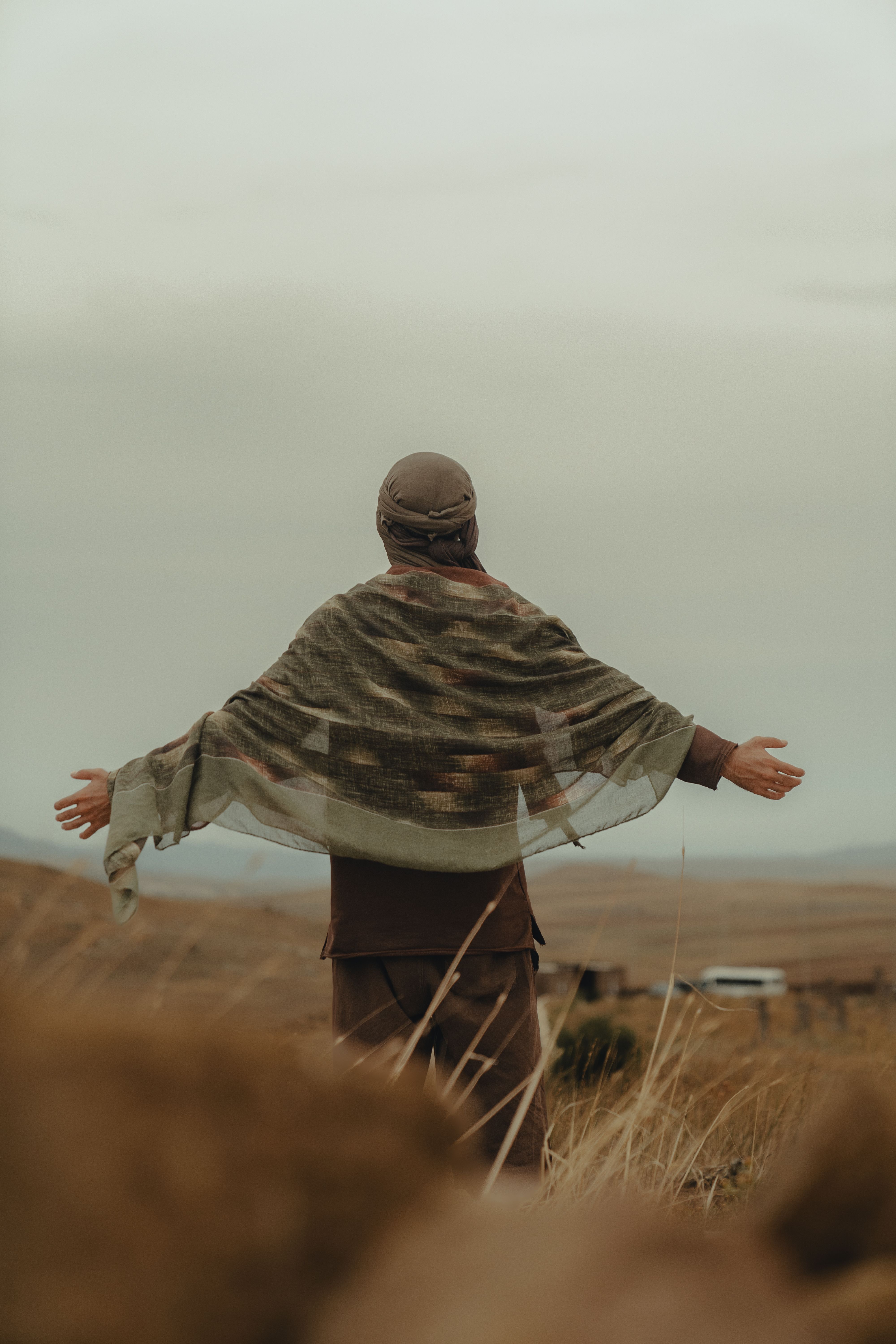 A person standing in the middle of a field with their arms outstretched ...