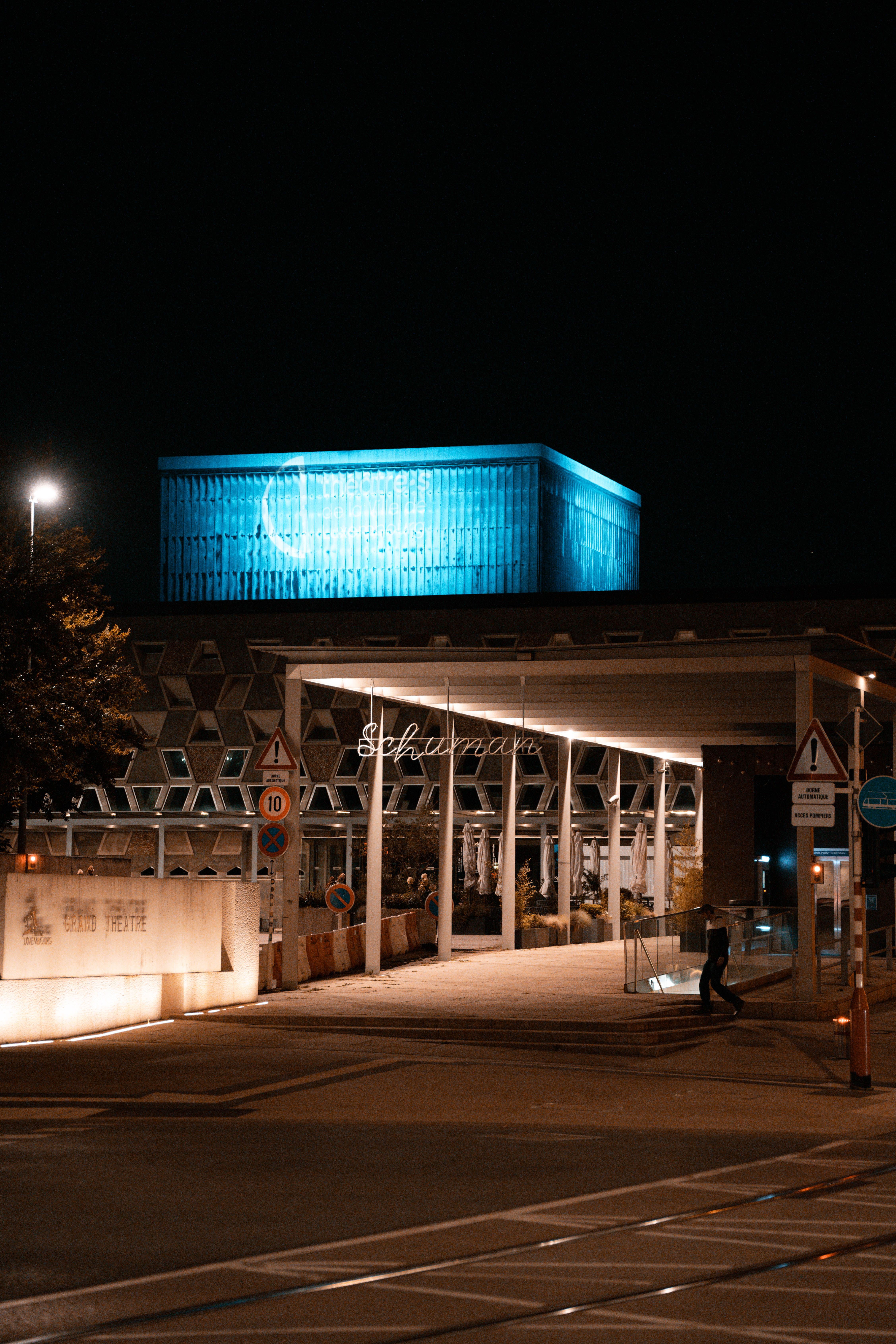 A building lit up with blue lights at night · Free Stock Photo