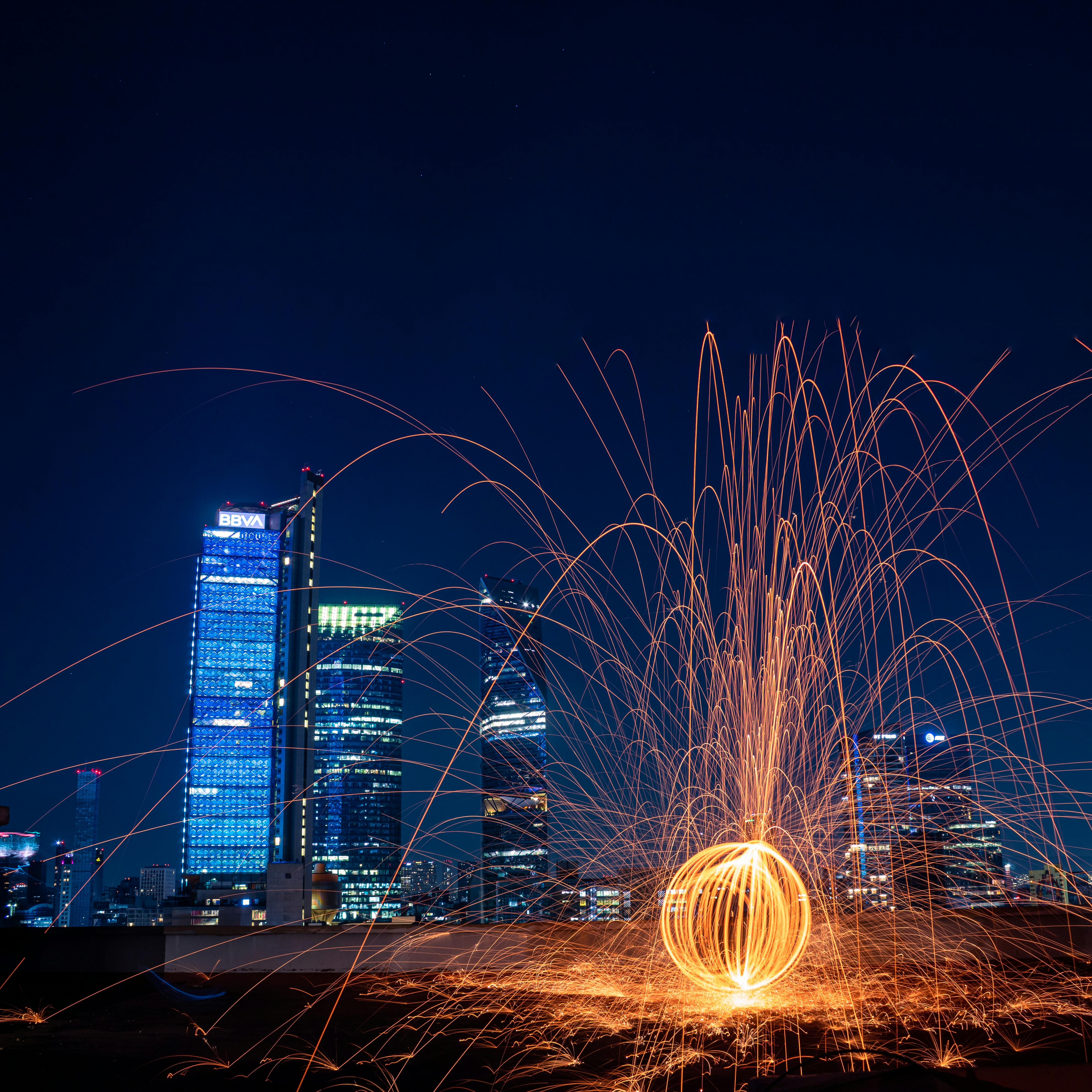 A steel wool ball is spinning in the air over a city · Free Stock Photo