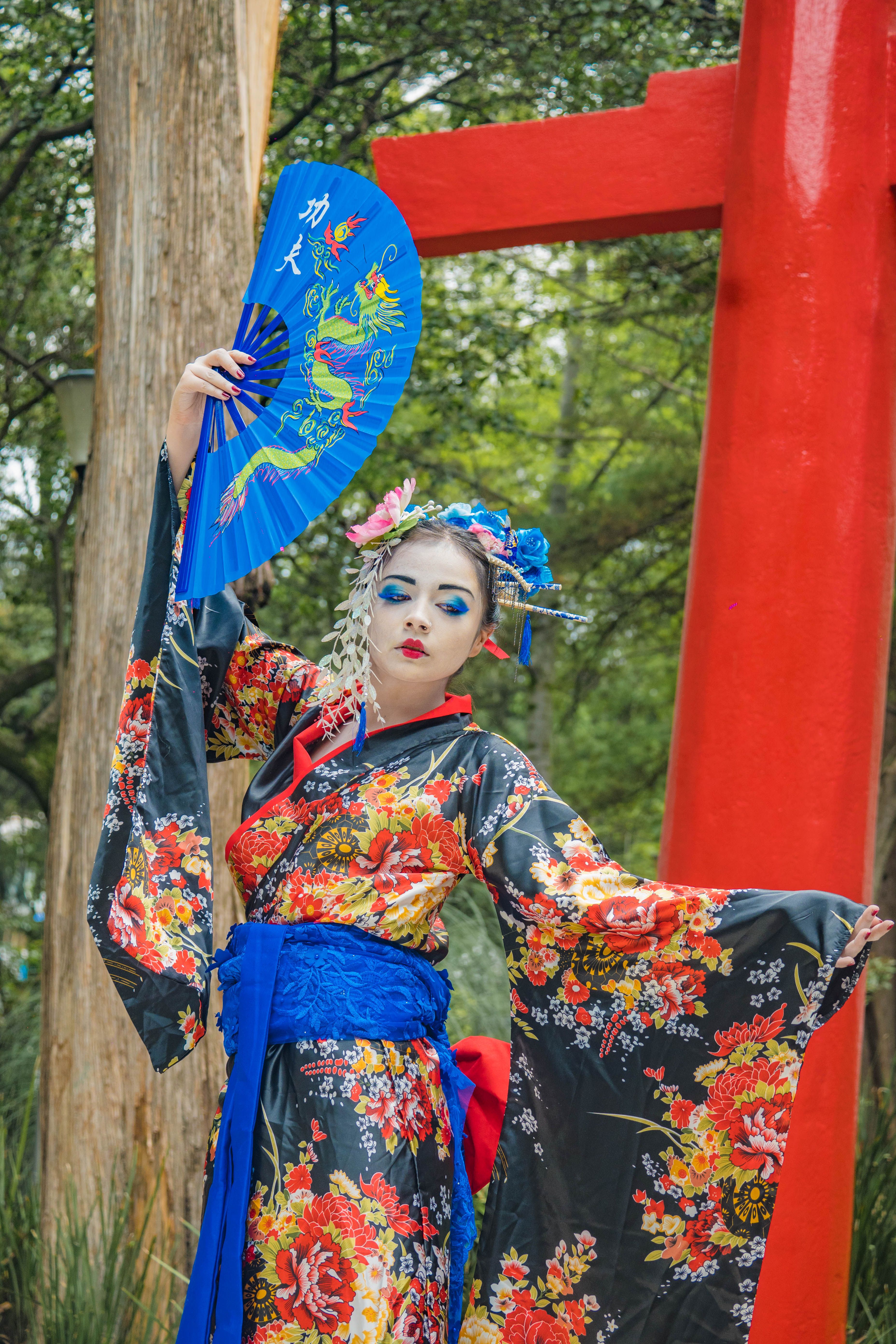 A woman in a geisha costume holding a fan · Free Stock Photo