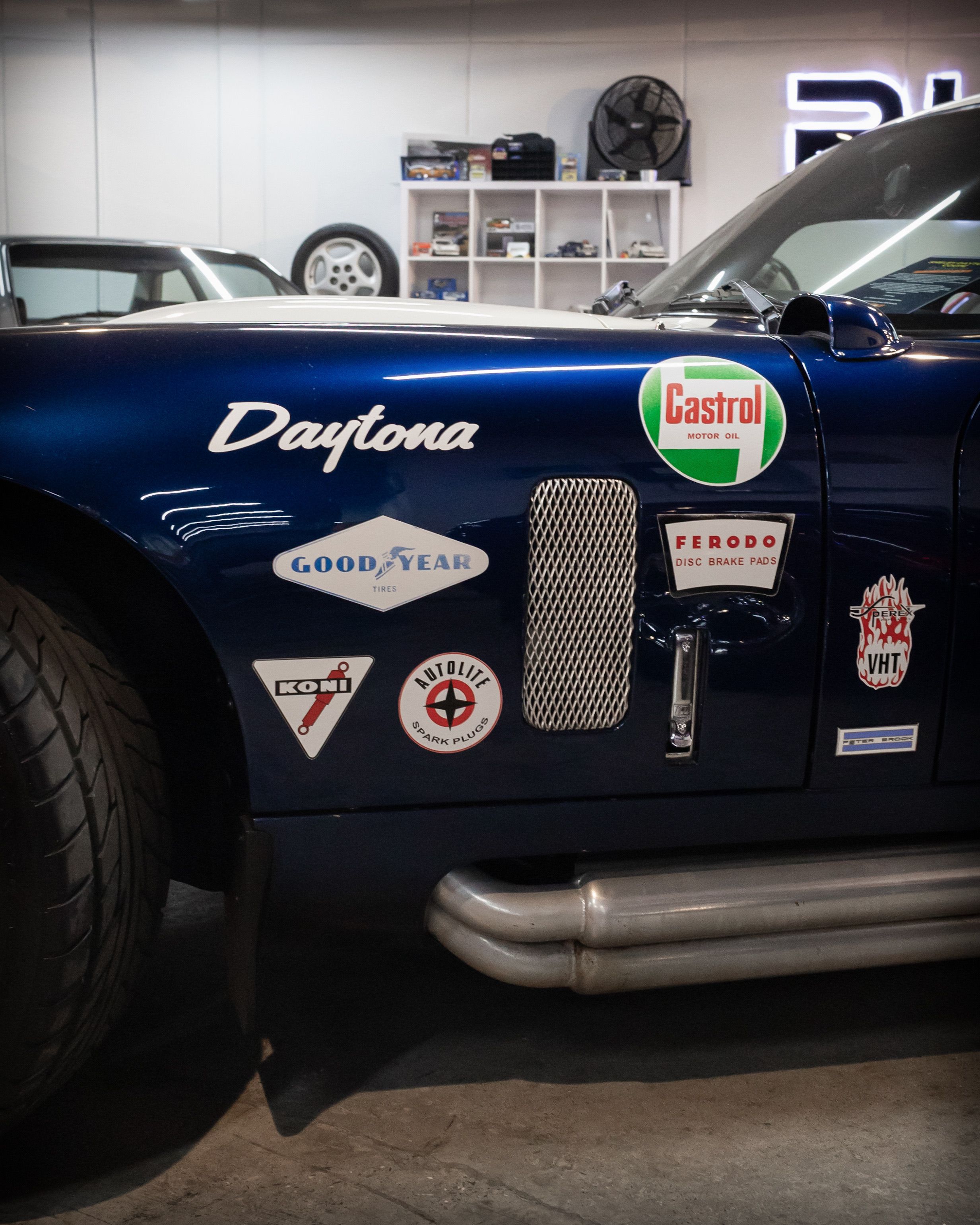 A blue and white sports car with a lot of stickers on it · Free Stock Photo