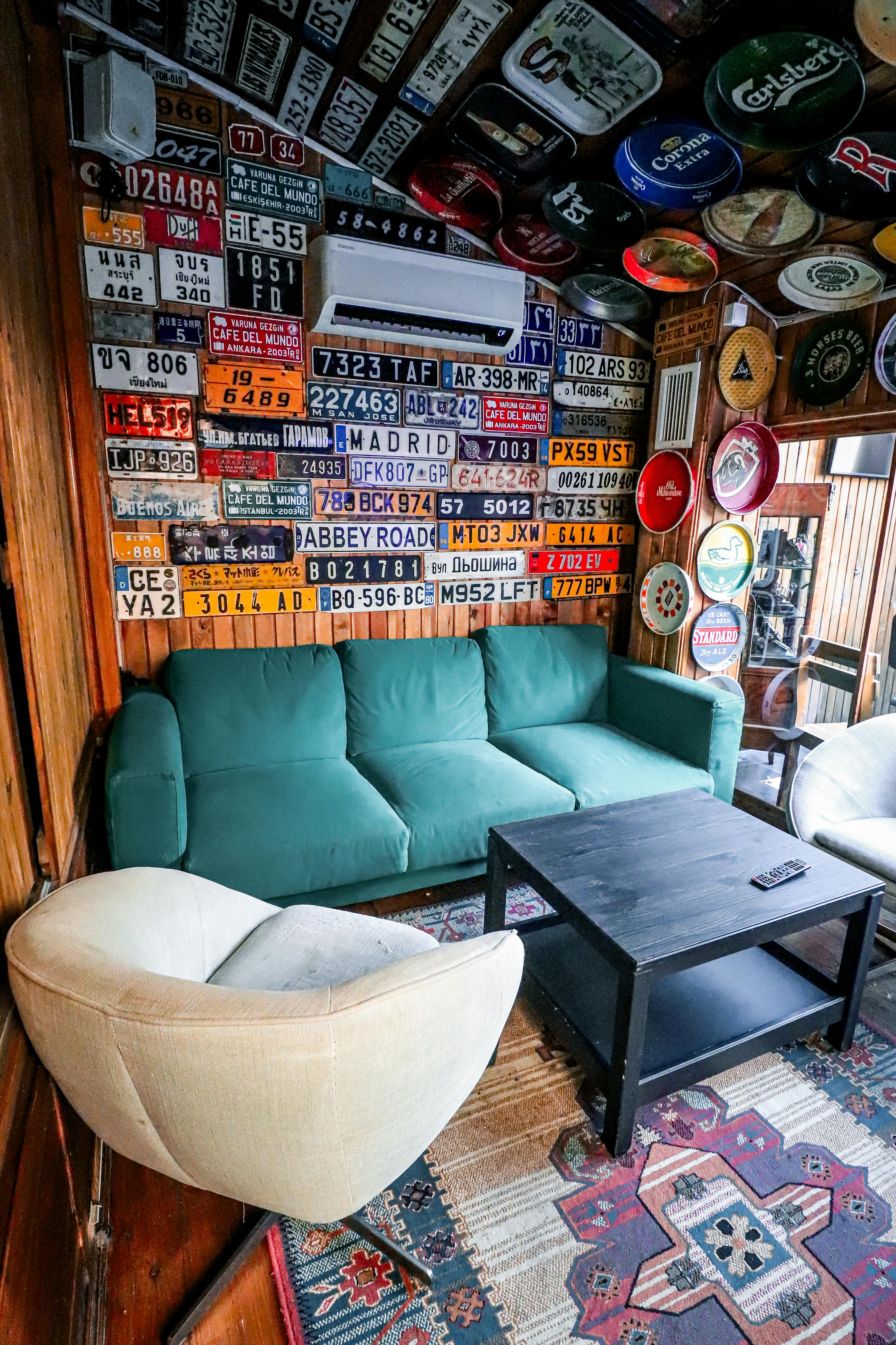 The living room has a couch, coffee table and a wall of license plates ...