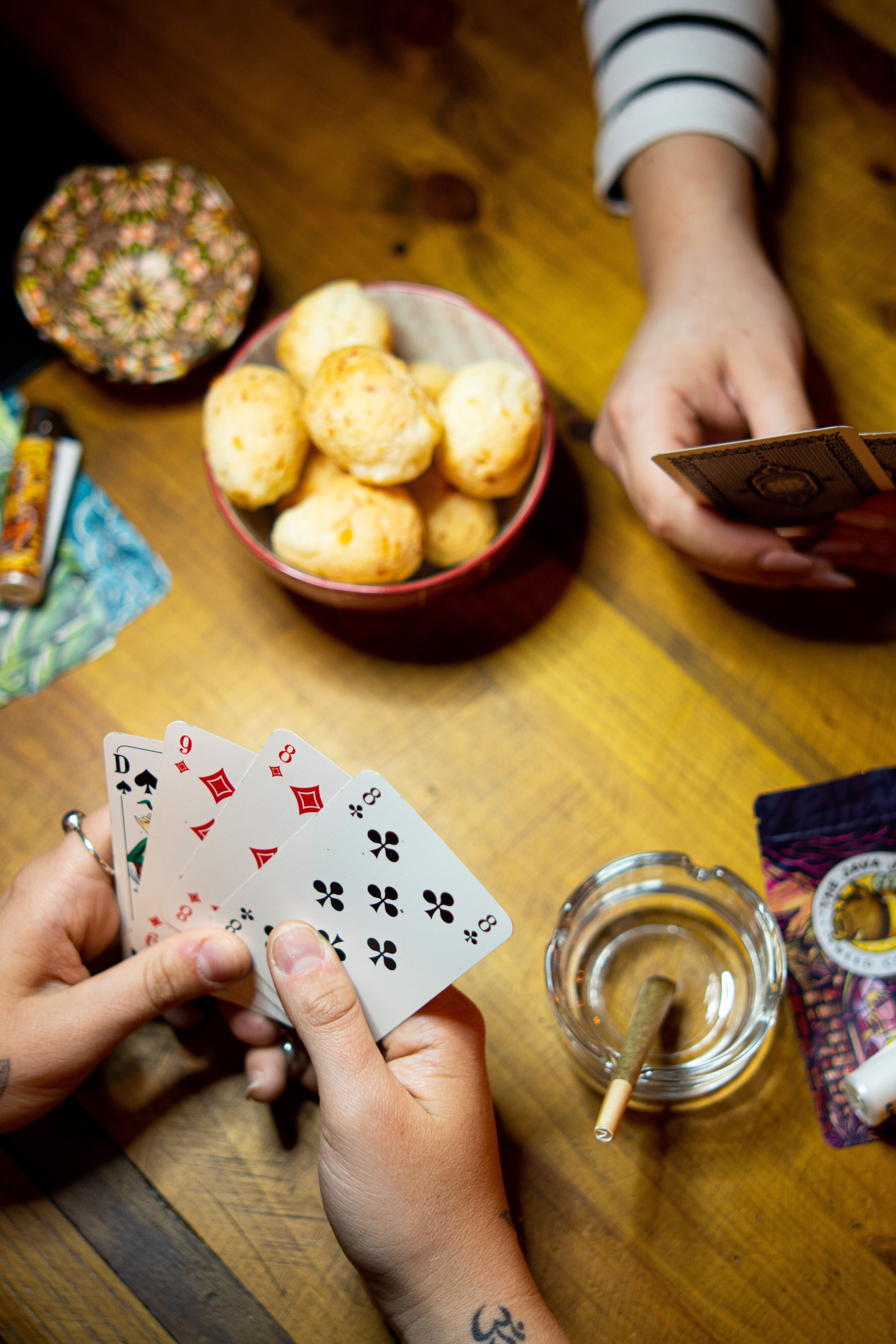 A group of people playing cards on a table · Free Stock Photo