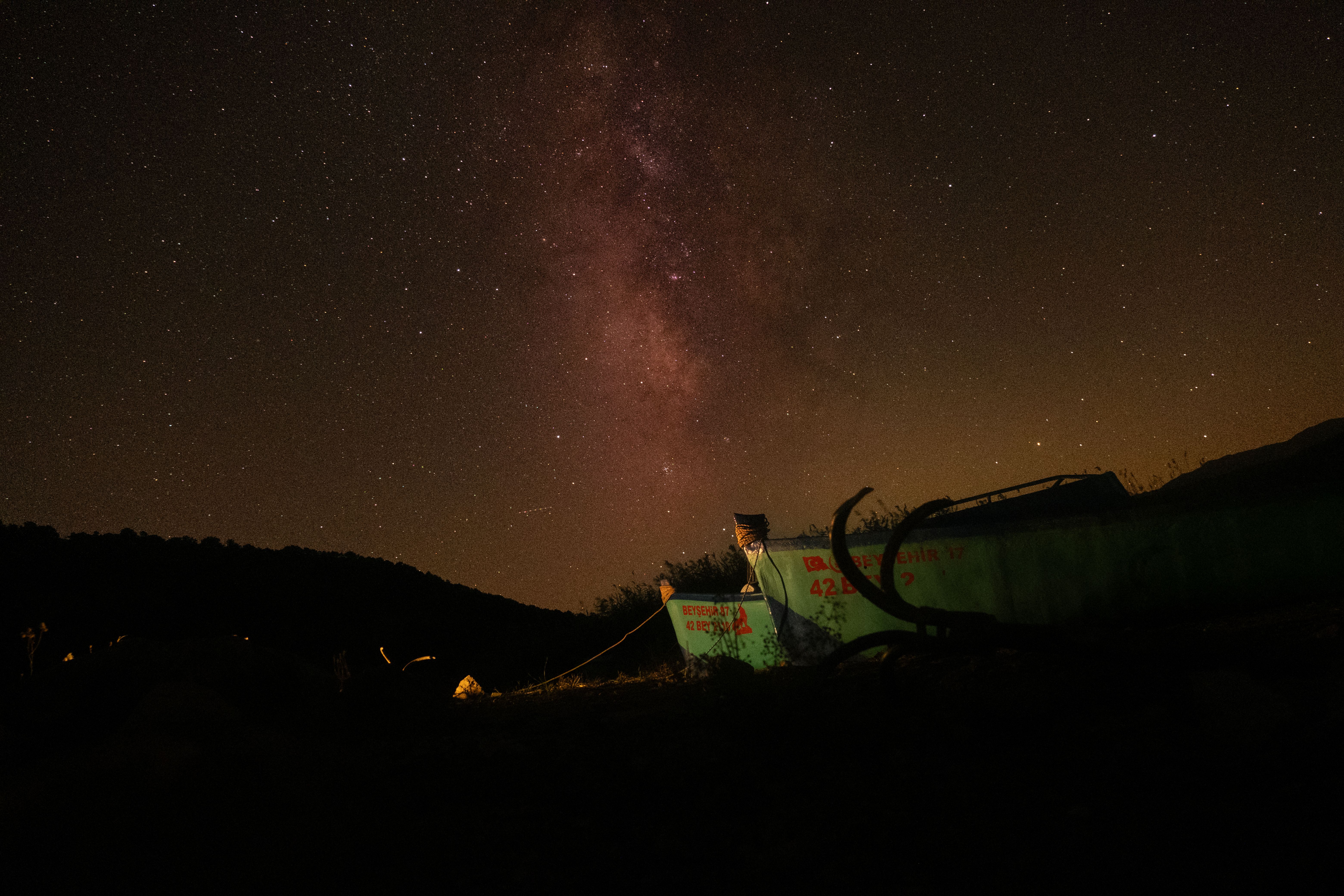 A boat is sitting on the shore under the stars · Free Stock Photo