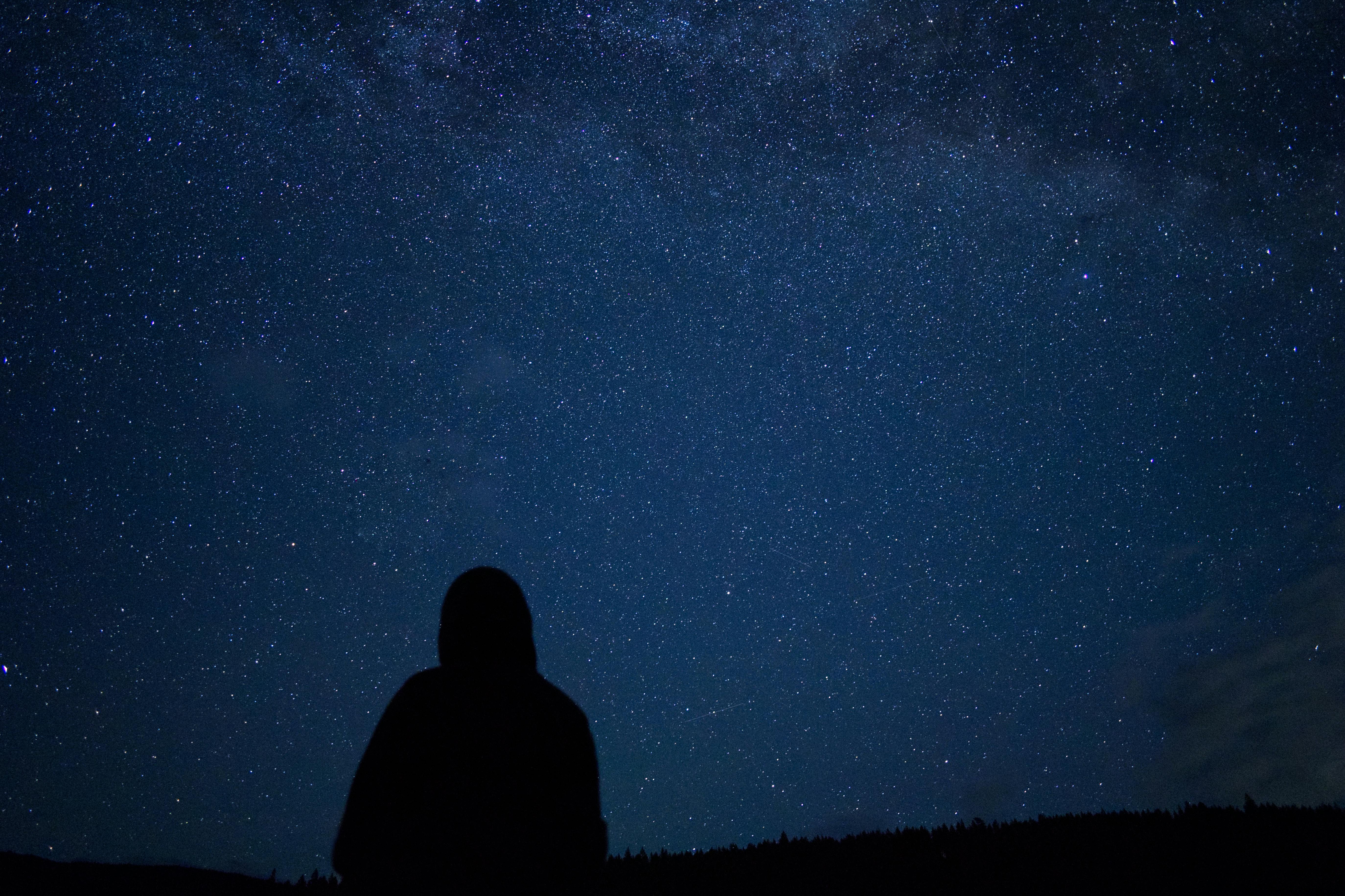 A person looking up at the night sky with stars · Free Stock Photo
