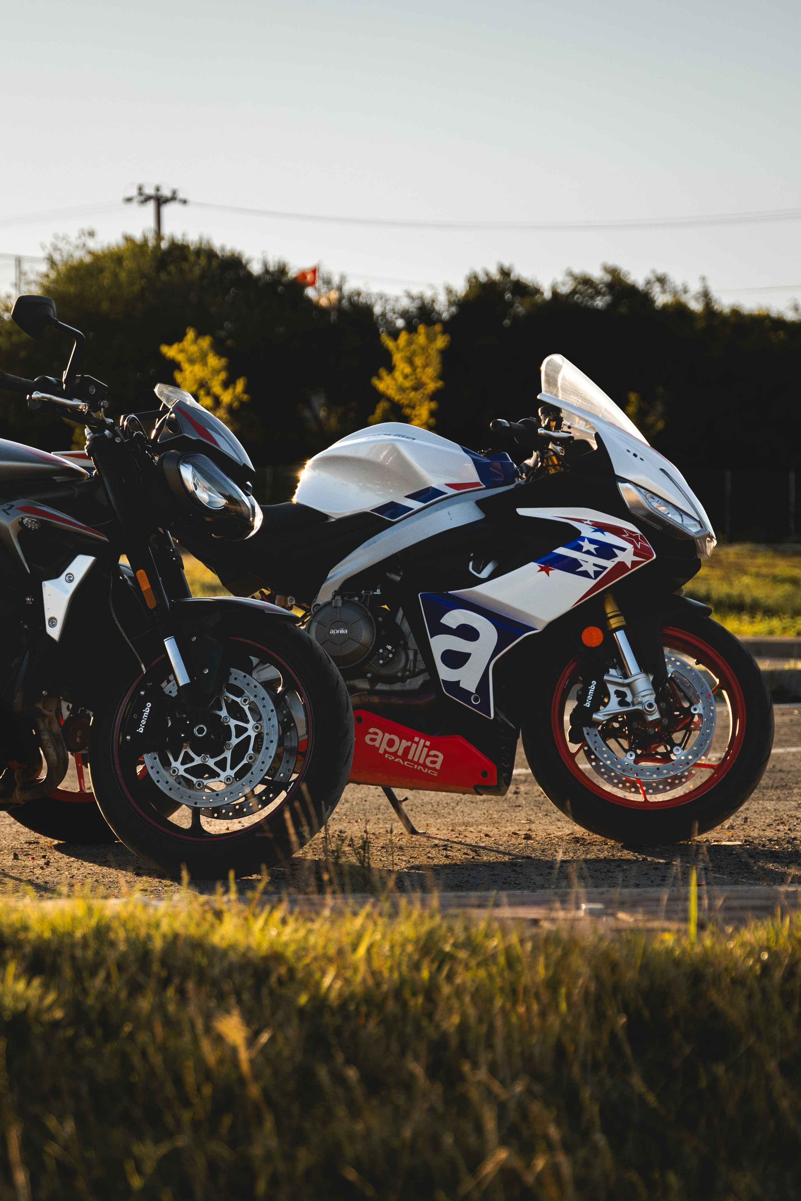 Two motorcycles parked next to each other on a road · Free Stock Photo