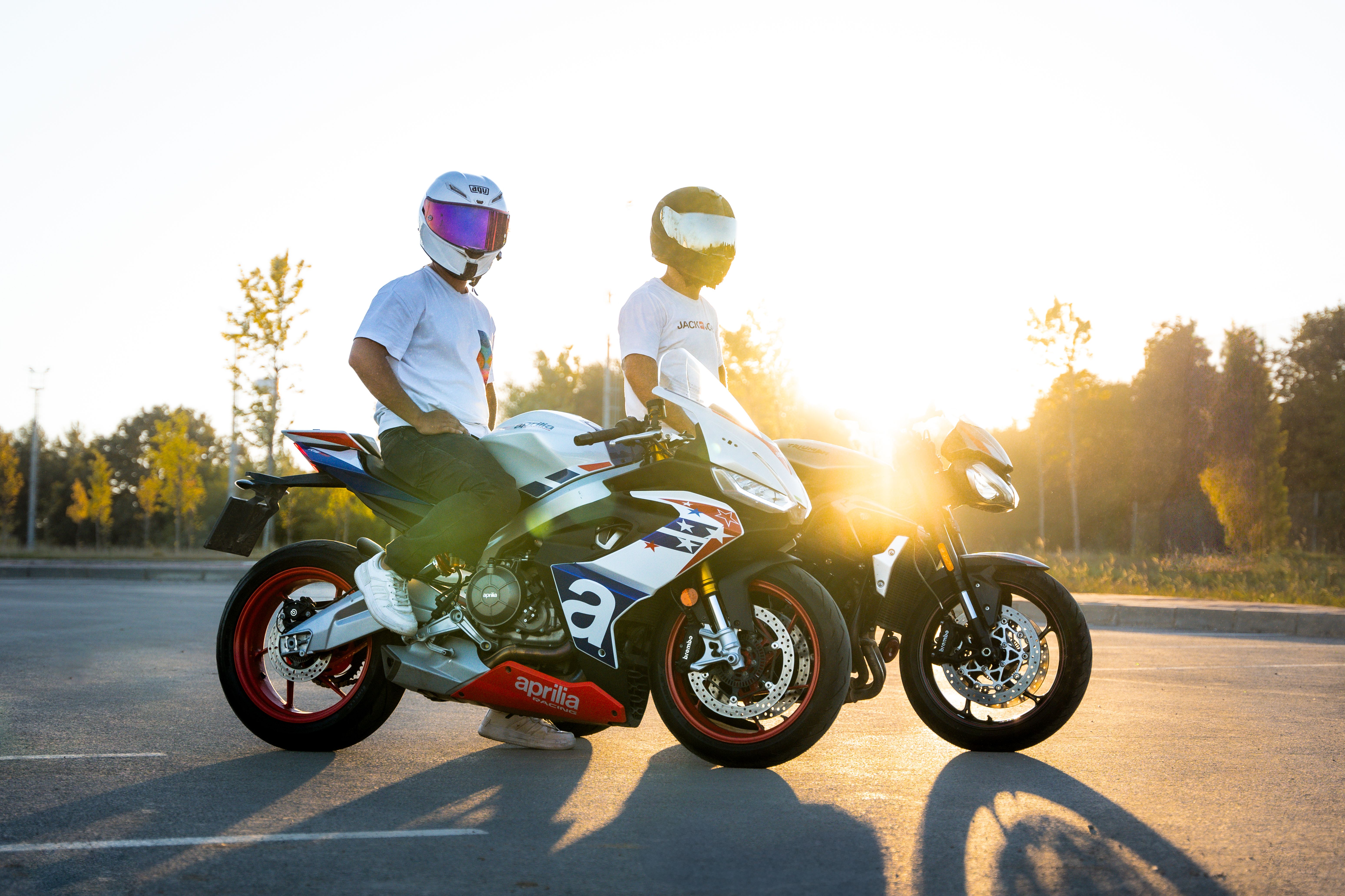 Two people are standing on motorcycles in the sun · Free Stock Photo