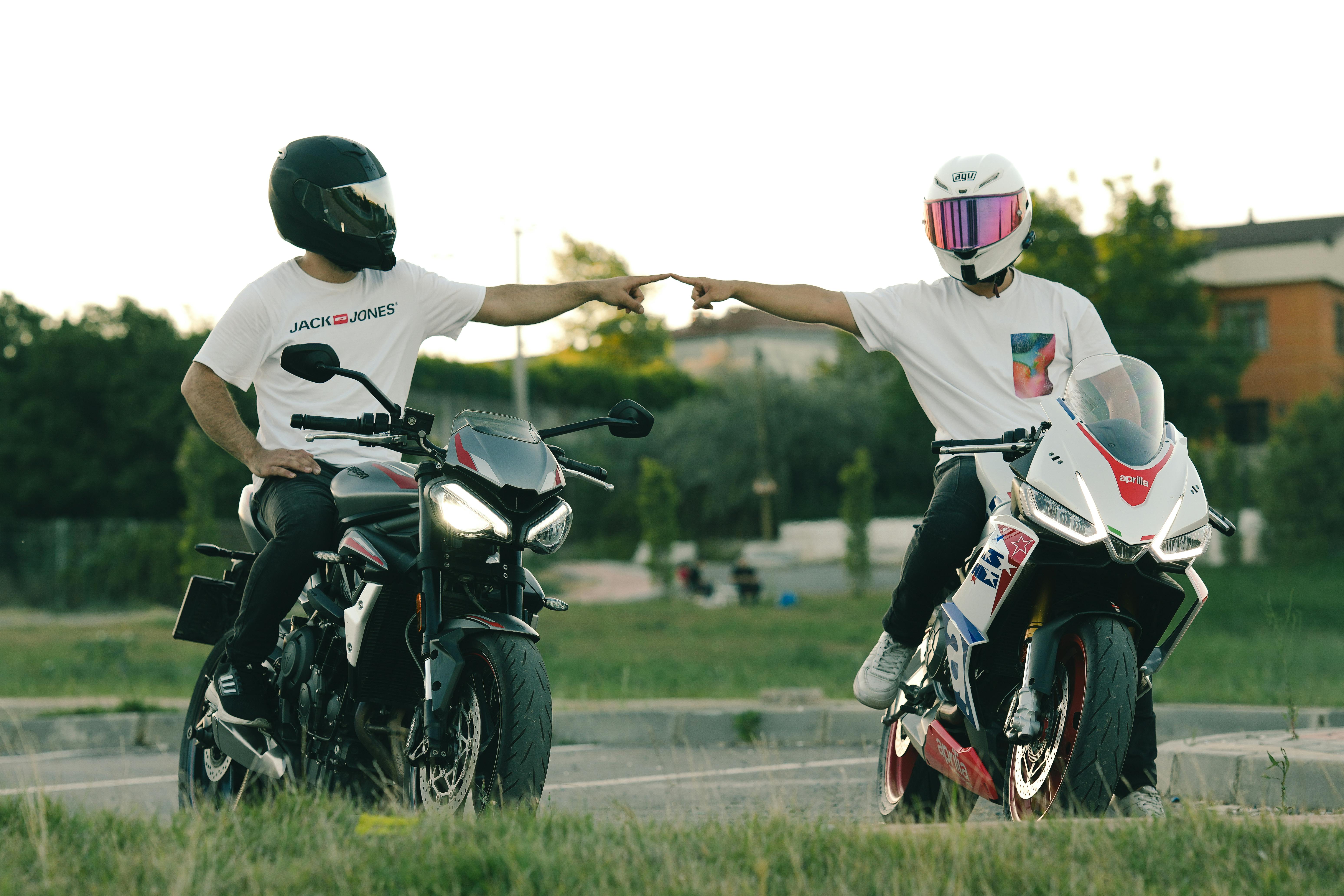 Two people on motorcycles are giving each other a high five · Free ...