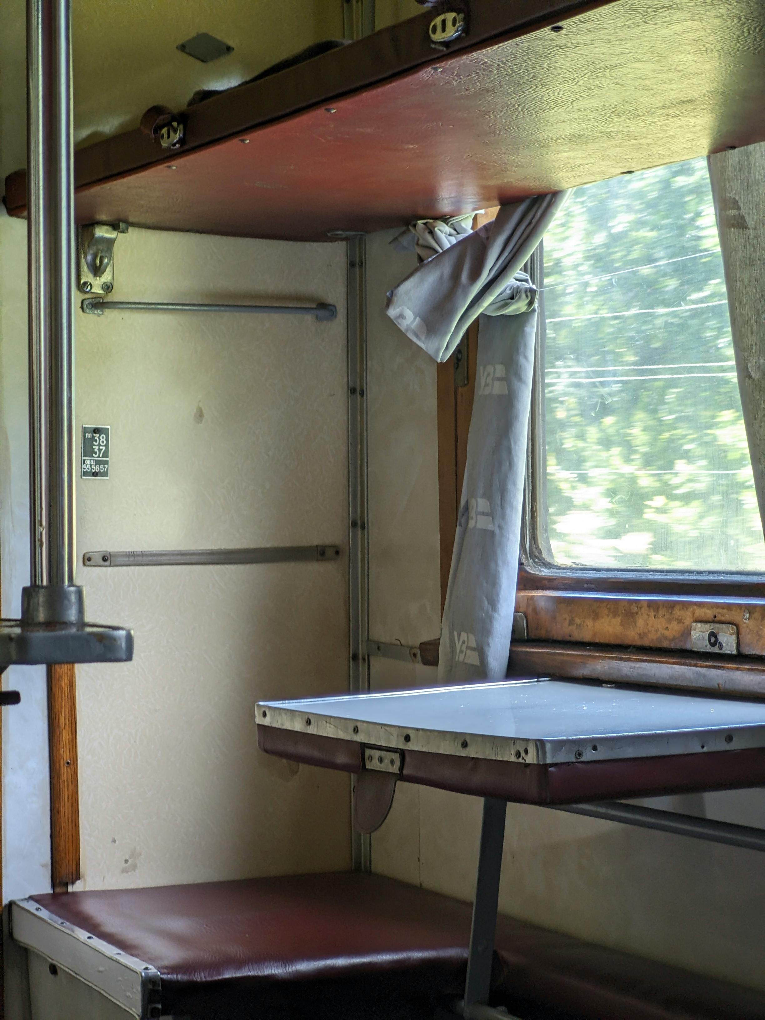 A small table and chair in a train car · Free Stock Photo