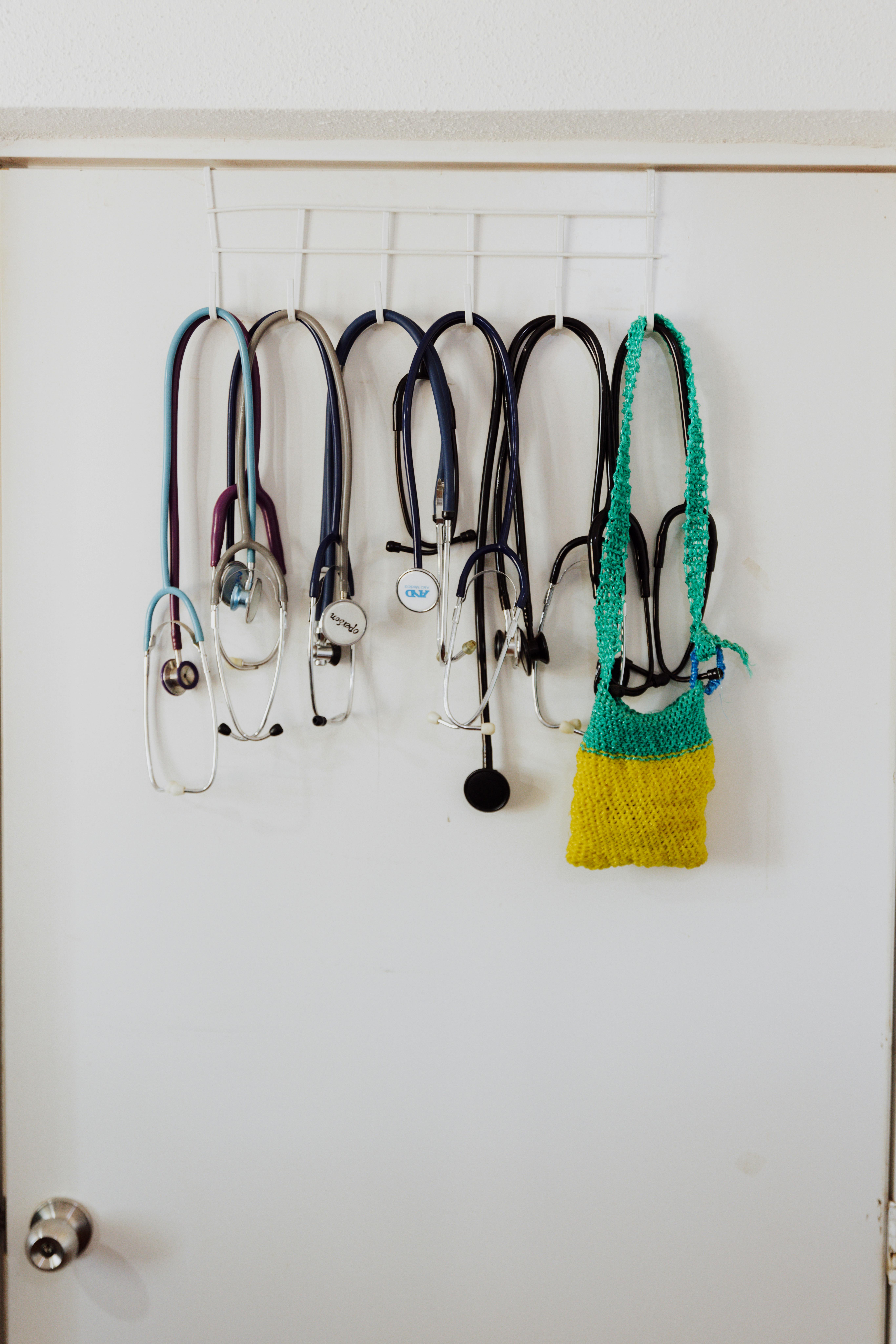 A rack of stethoscopes hanging on a wall · Free Stock Photo
