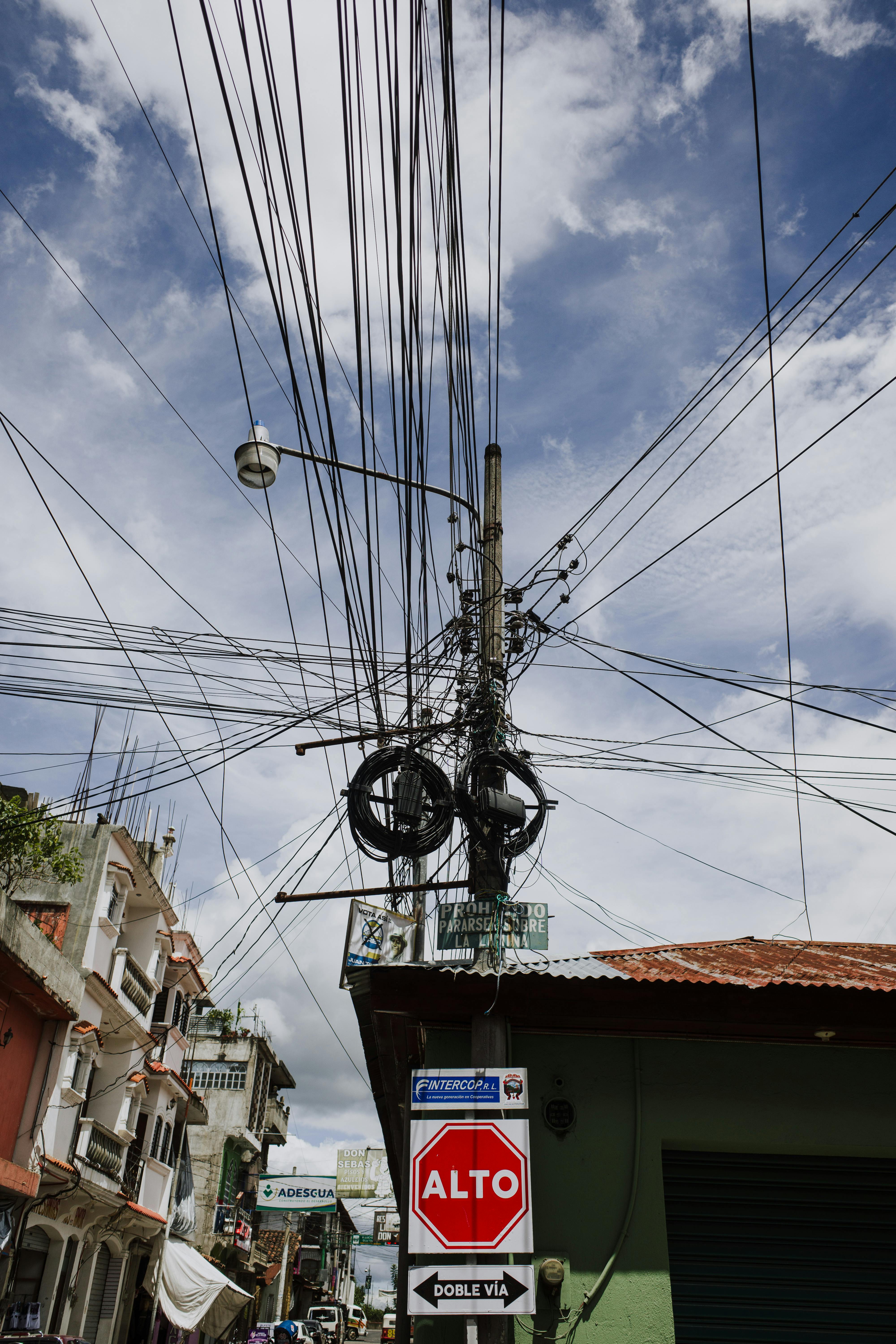 A stop sign on a street with power lines · Free Stock Photo