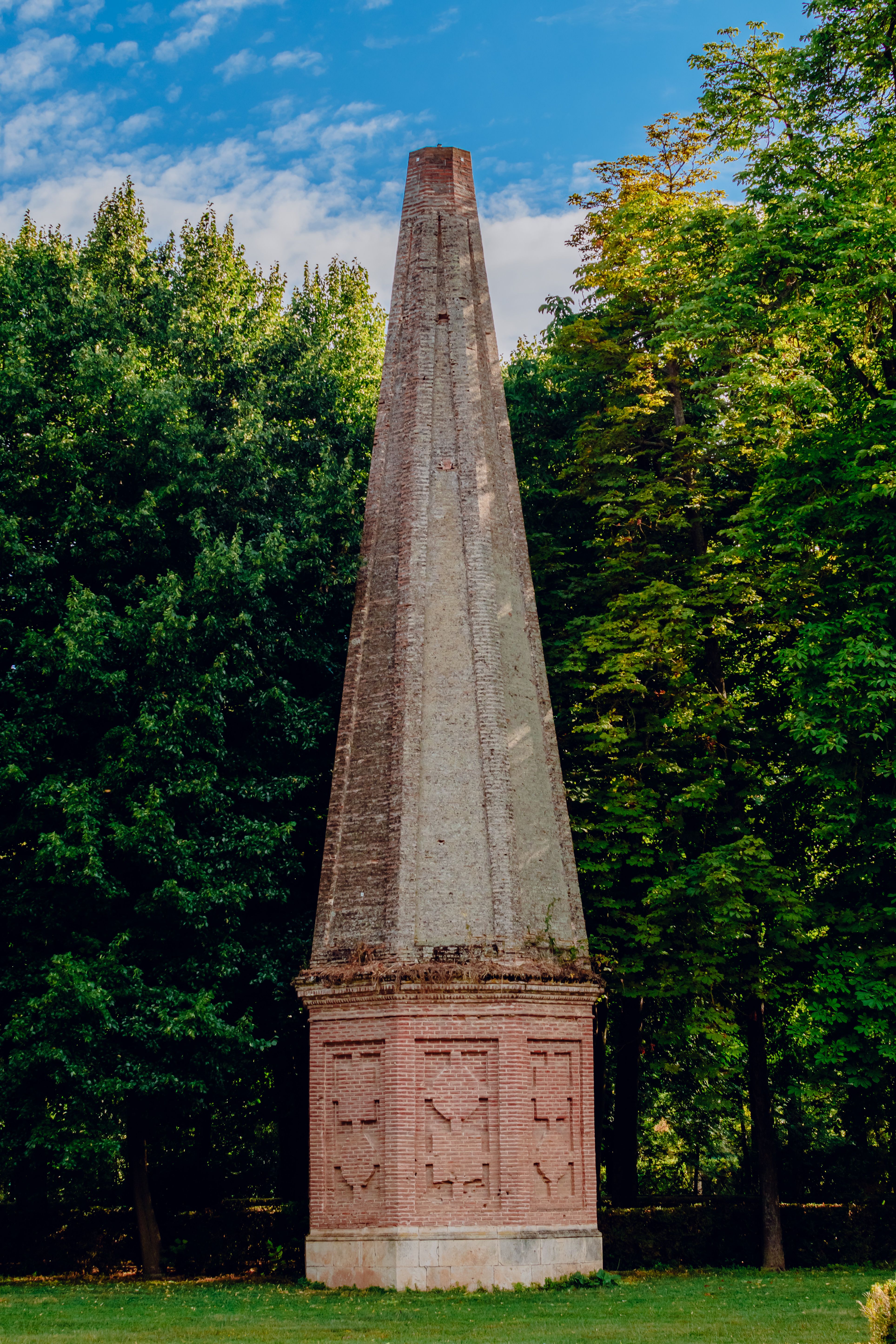 A monument with a tall tower in the middle of a forest · Free Stock Photo
