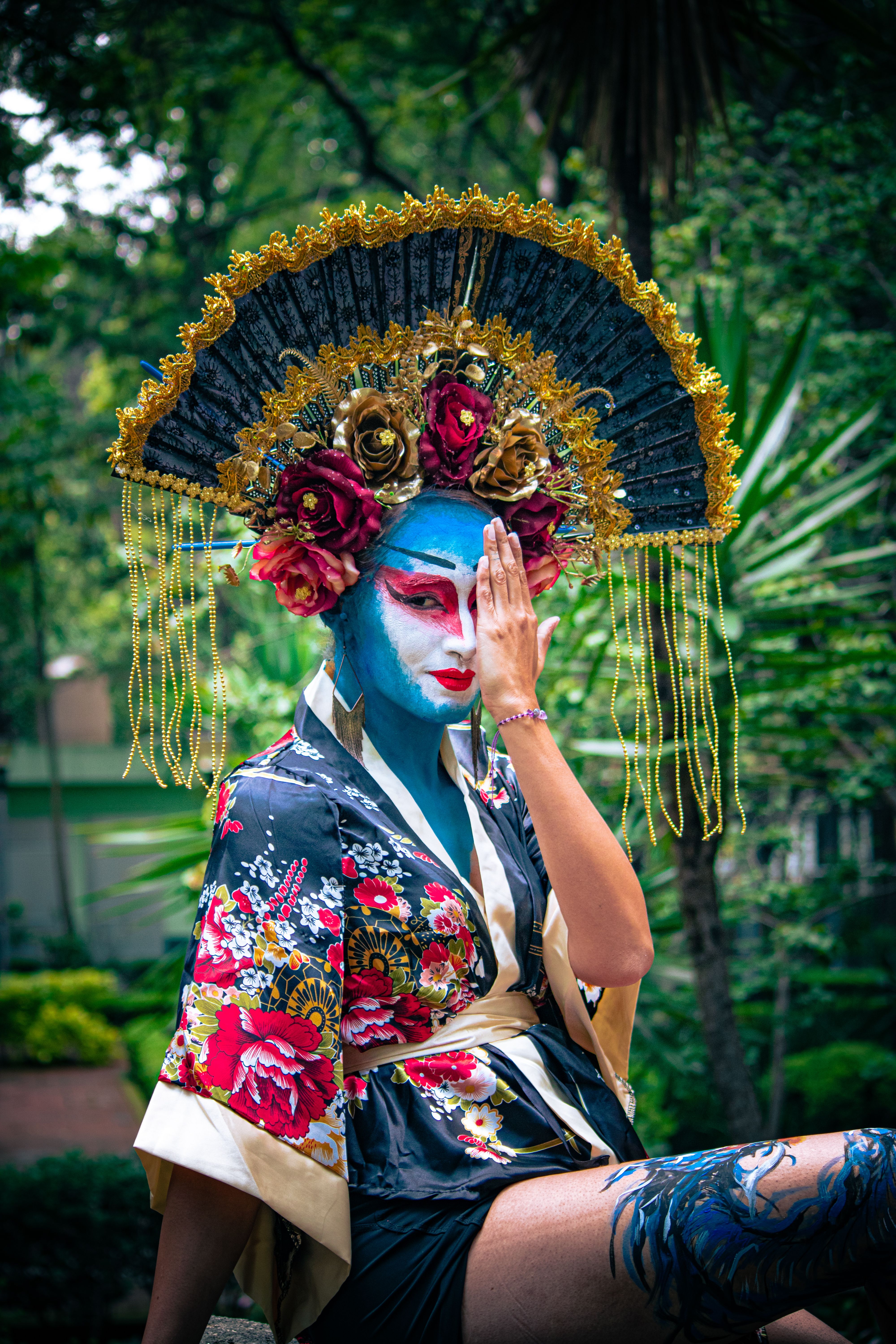 A woman with blue face paint and a headdress · Free Stock Photo