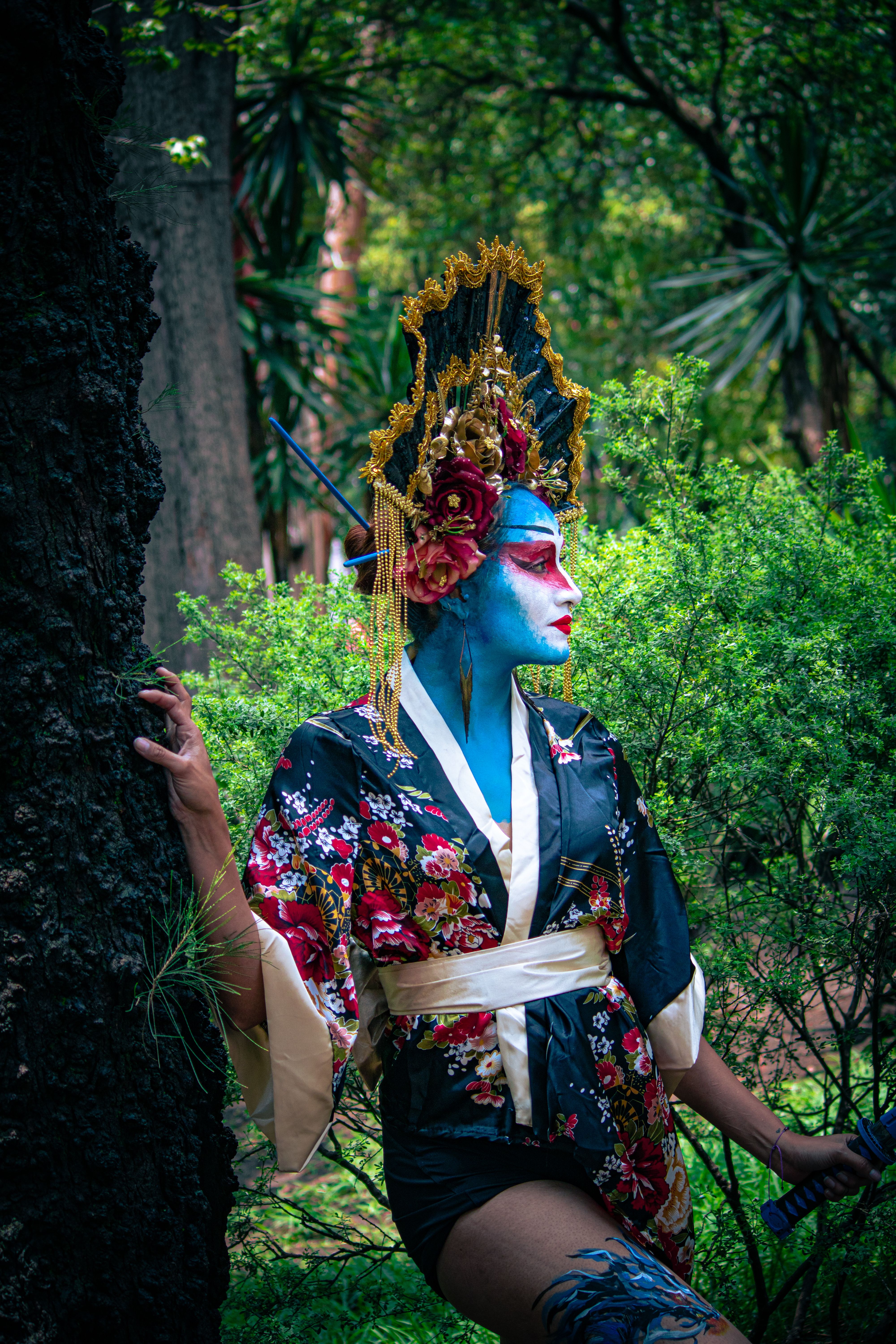 A woman in a blue and black costume with blue face paint · Free Stock Photo