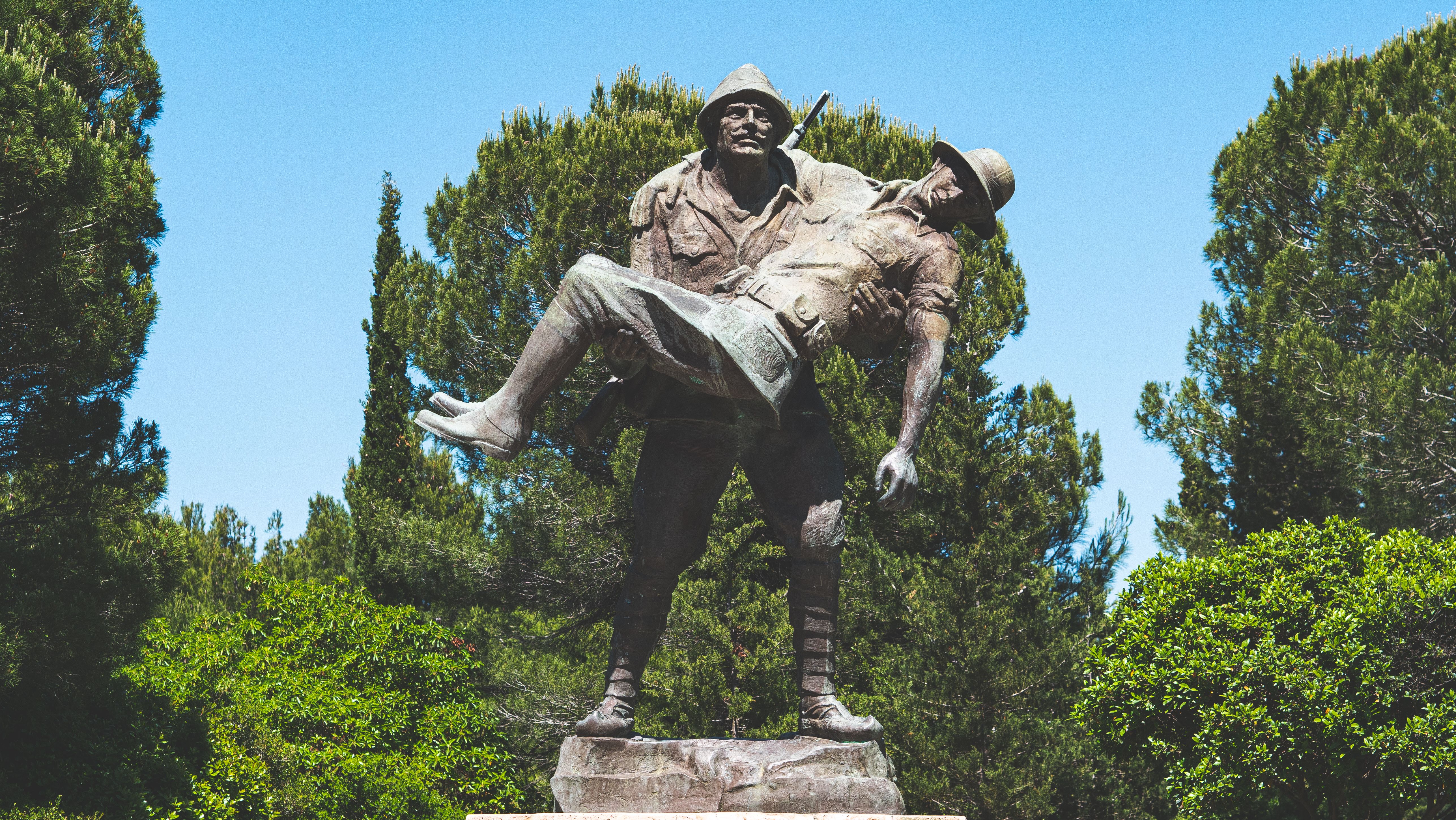 A statue of a soldier carrying a man · Free Stock Photo