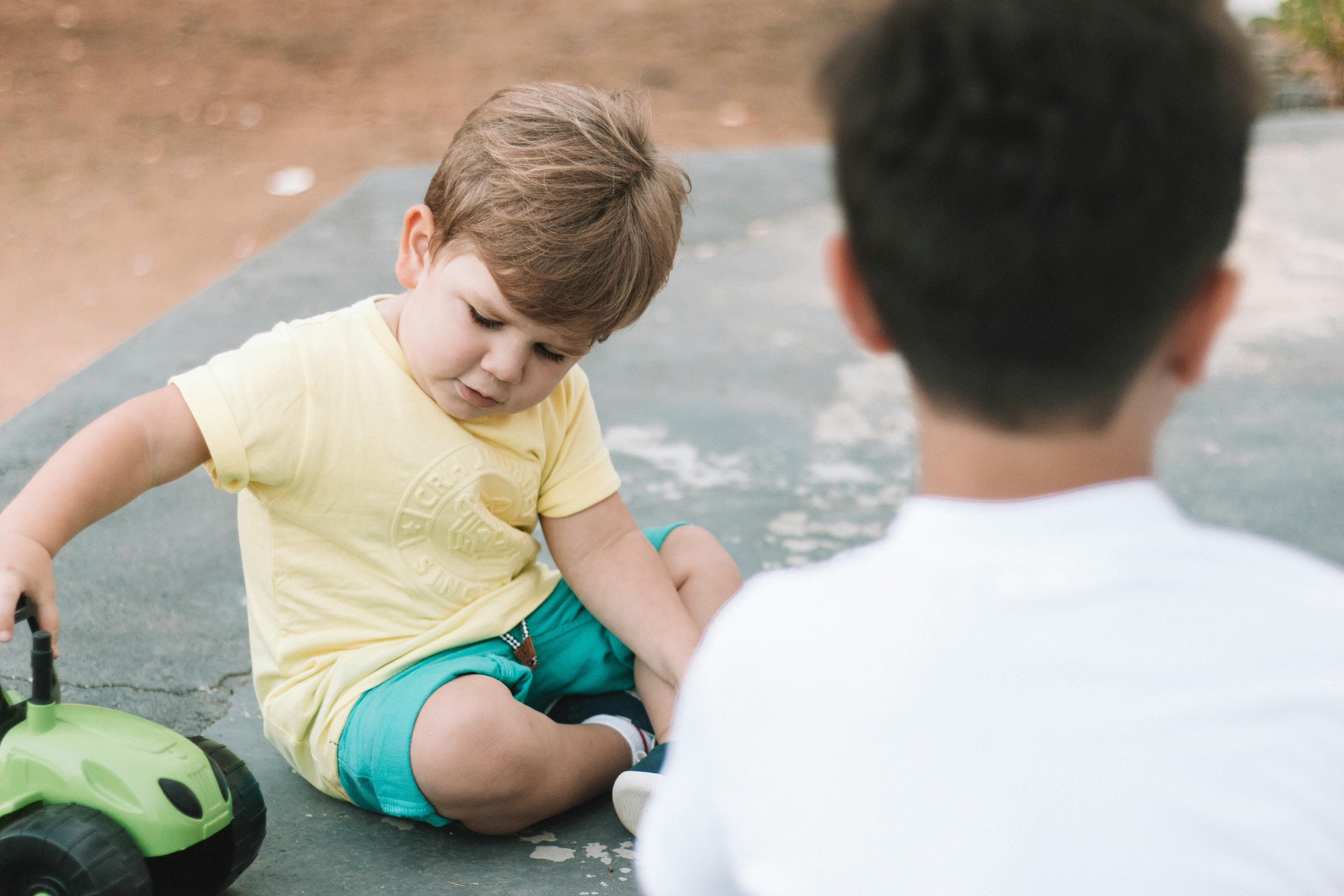 Child In Grey Shorts Sitting On Road · Free Stock Photo