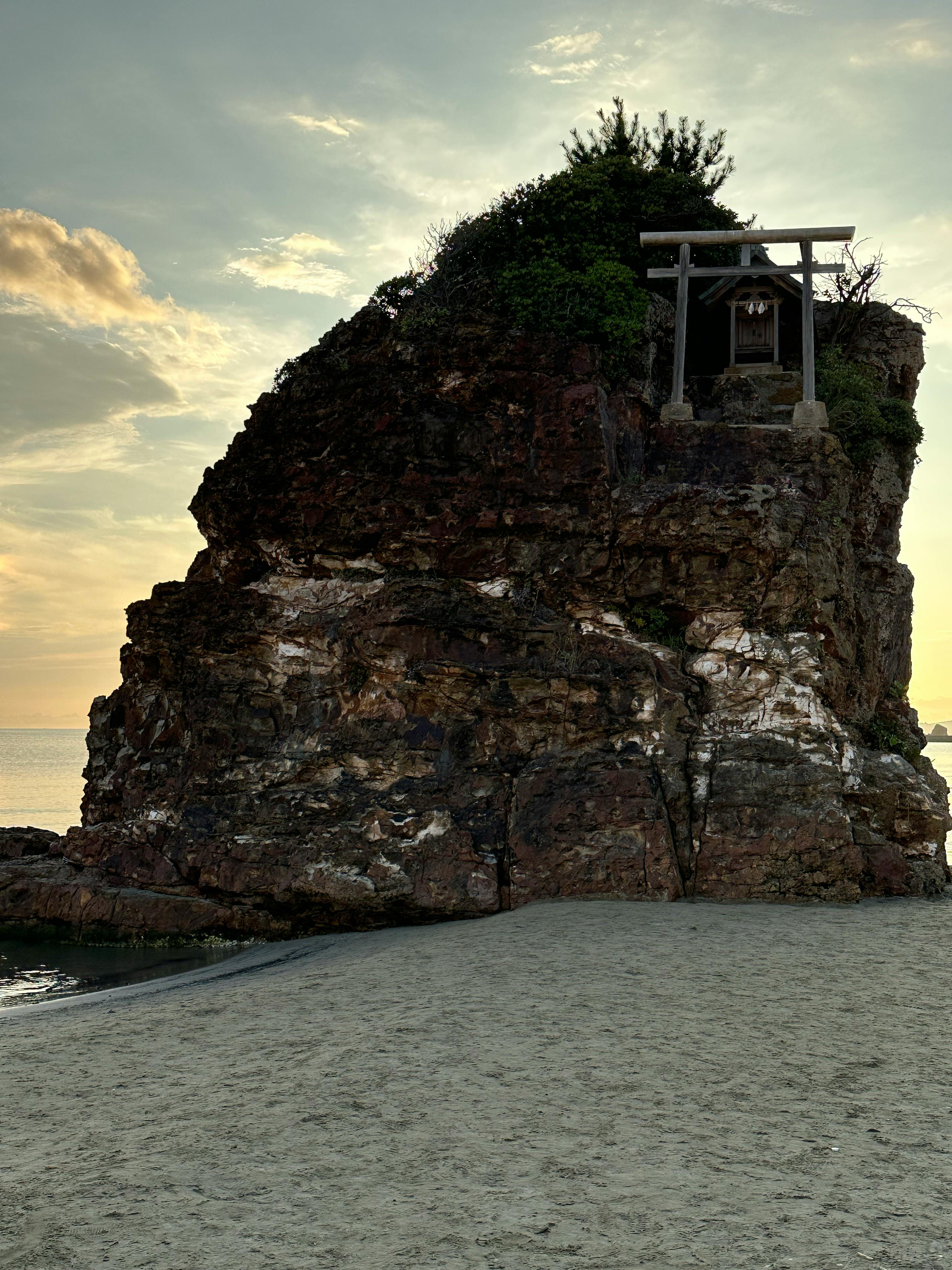 A small stone structure sits on top of a rock at the beach · Free Stock ...