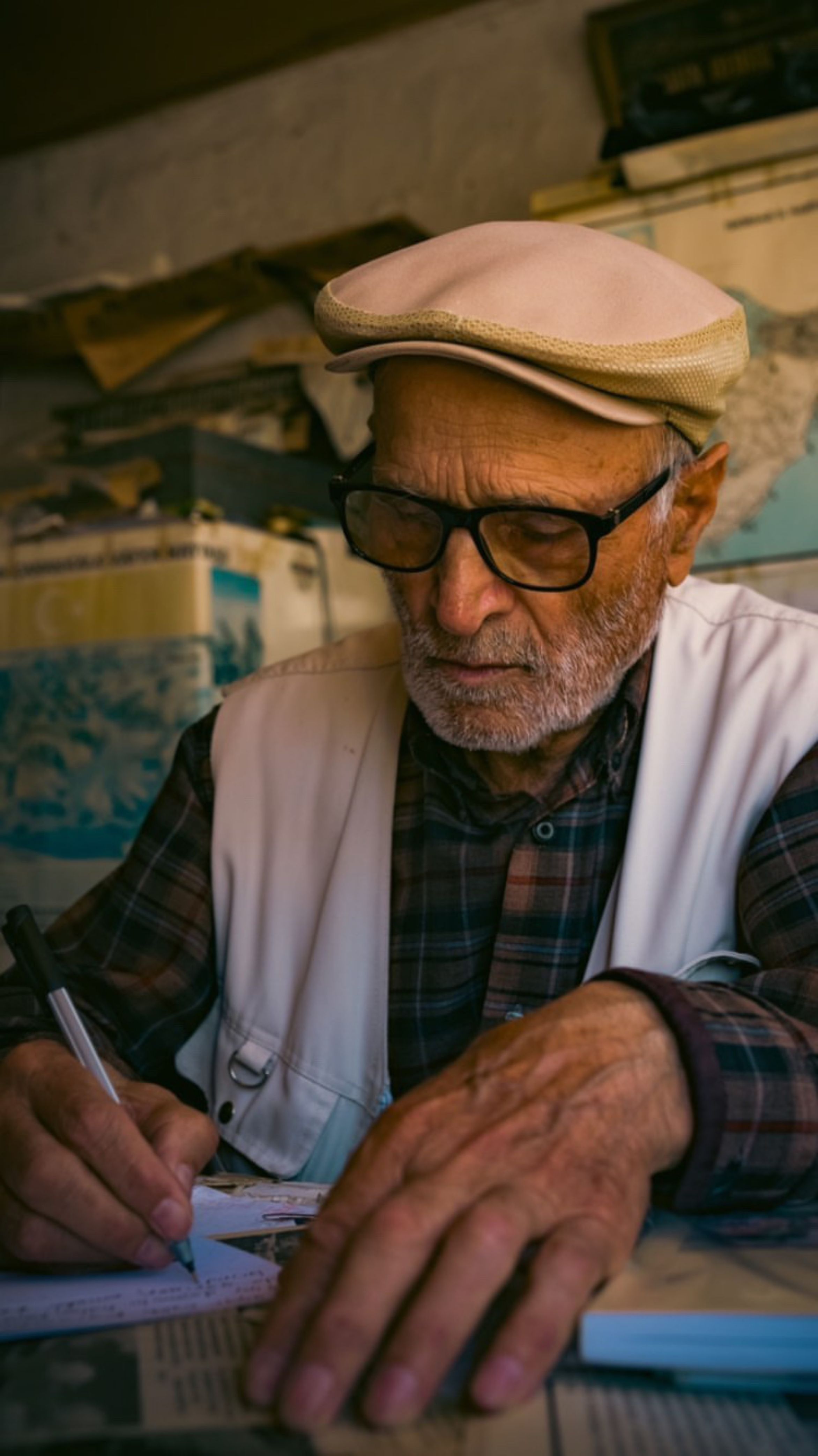 An old man writing in a notebook · Free Stock Photo
