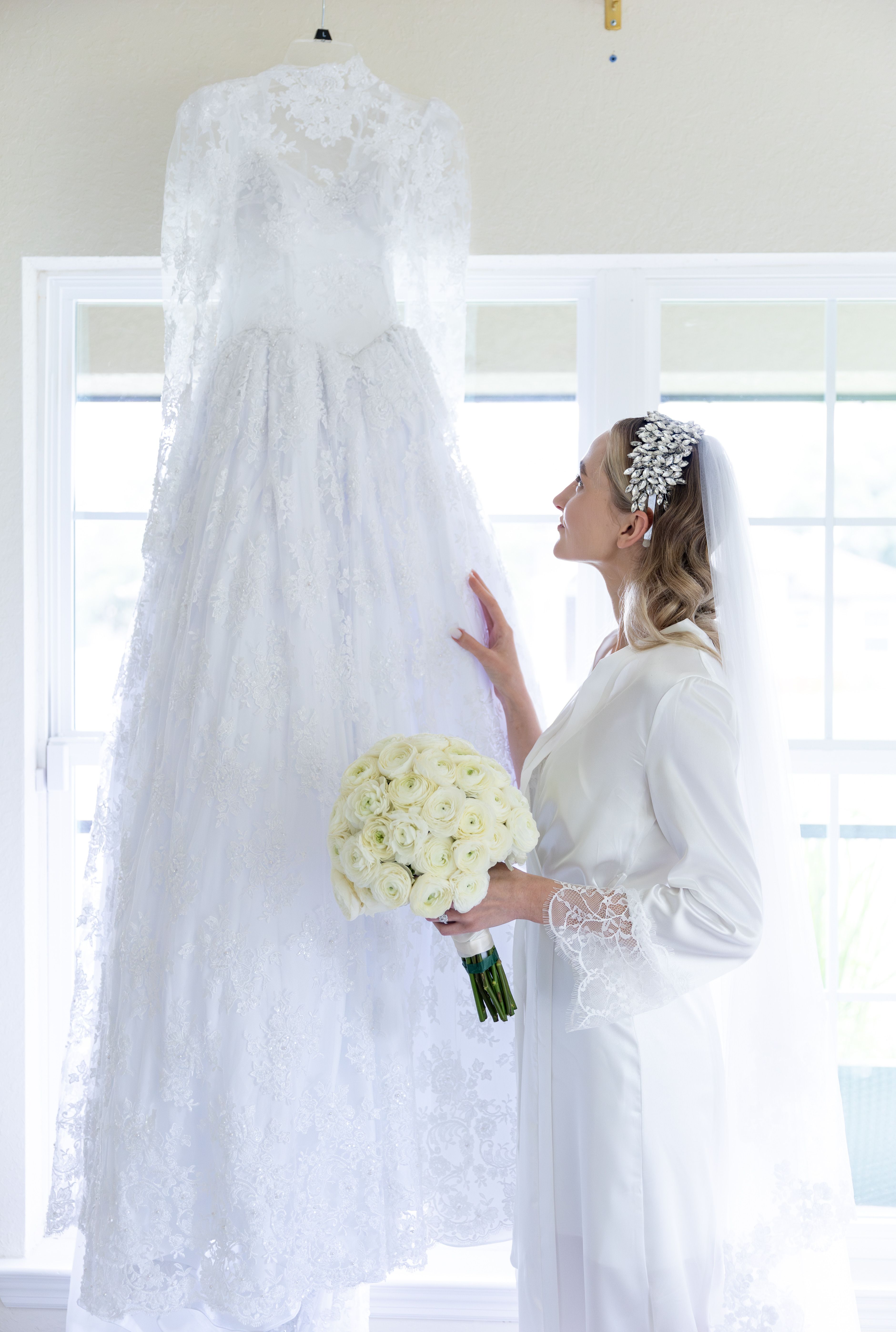 A bride is holding up her wedding dress · Free Stock Photo