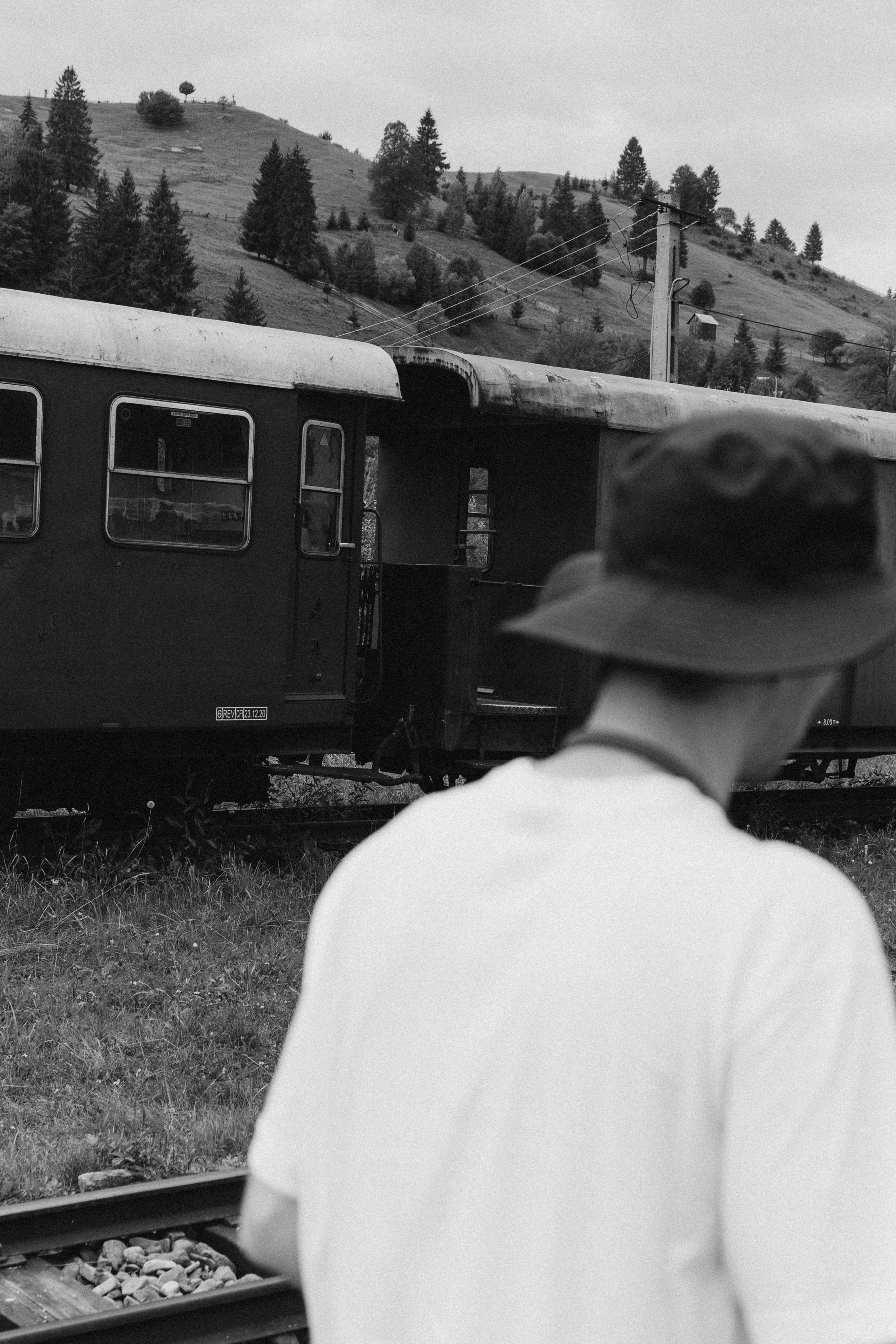A man in a hat is standing next to a train · Free Stock Photo