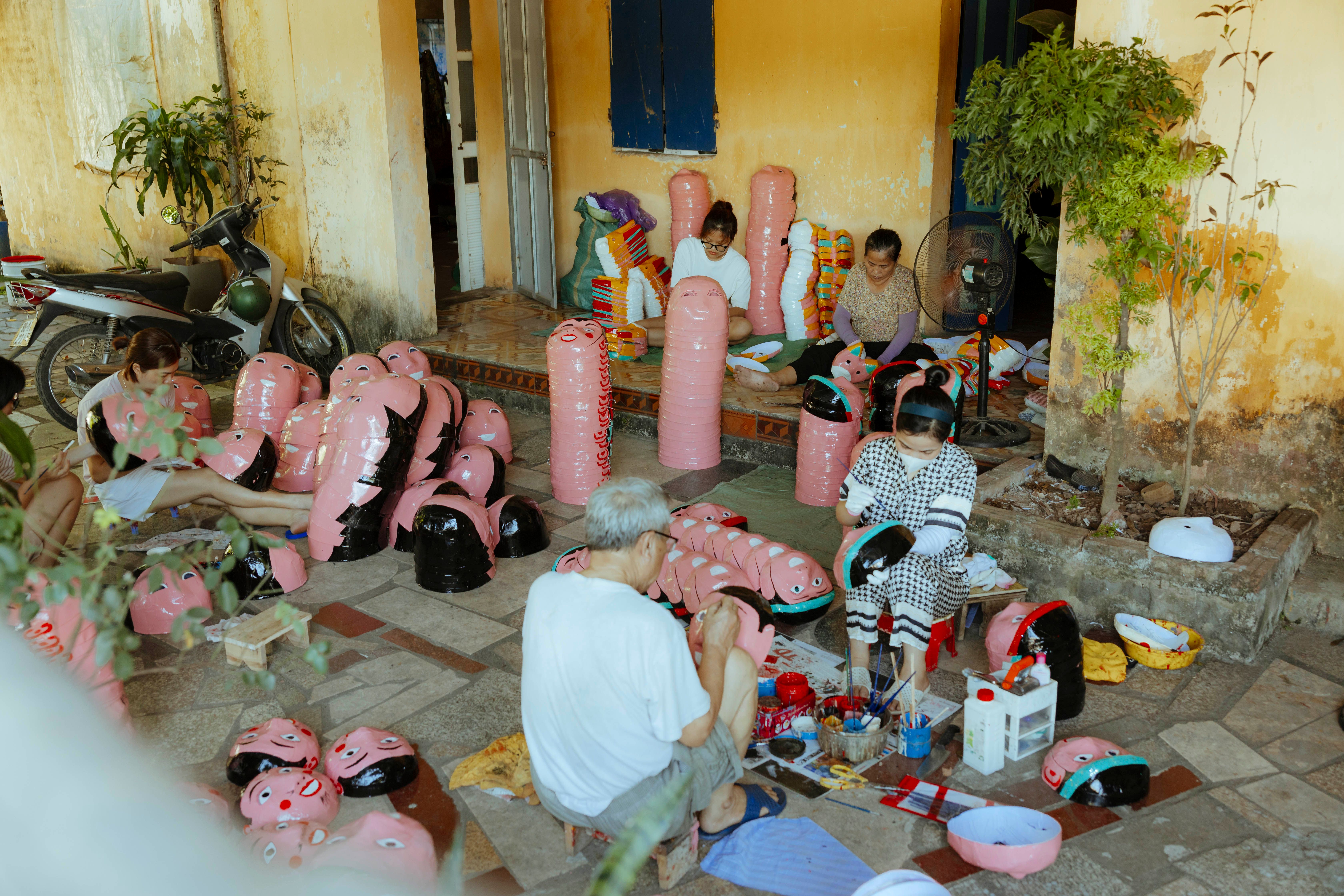 A group of people sitting on the ground next to a building · Free Stock ...