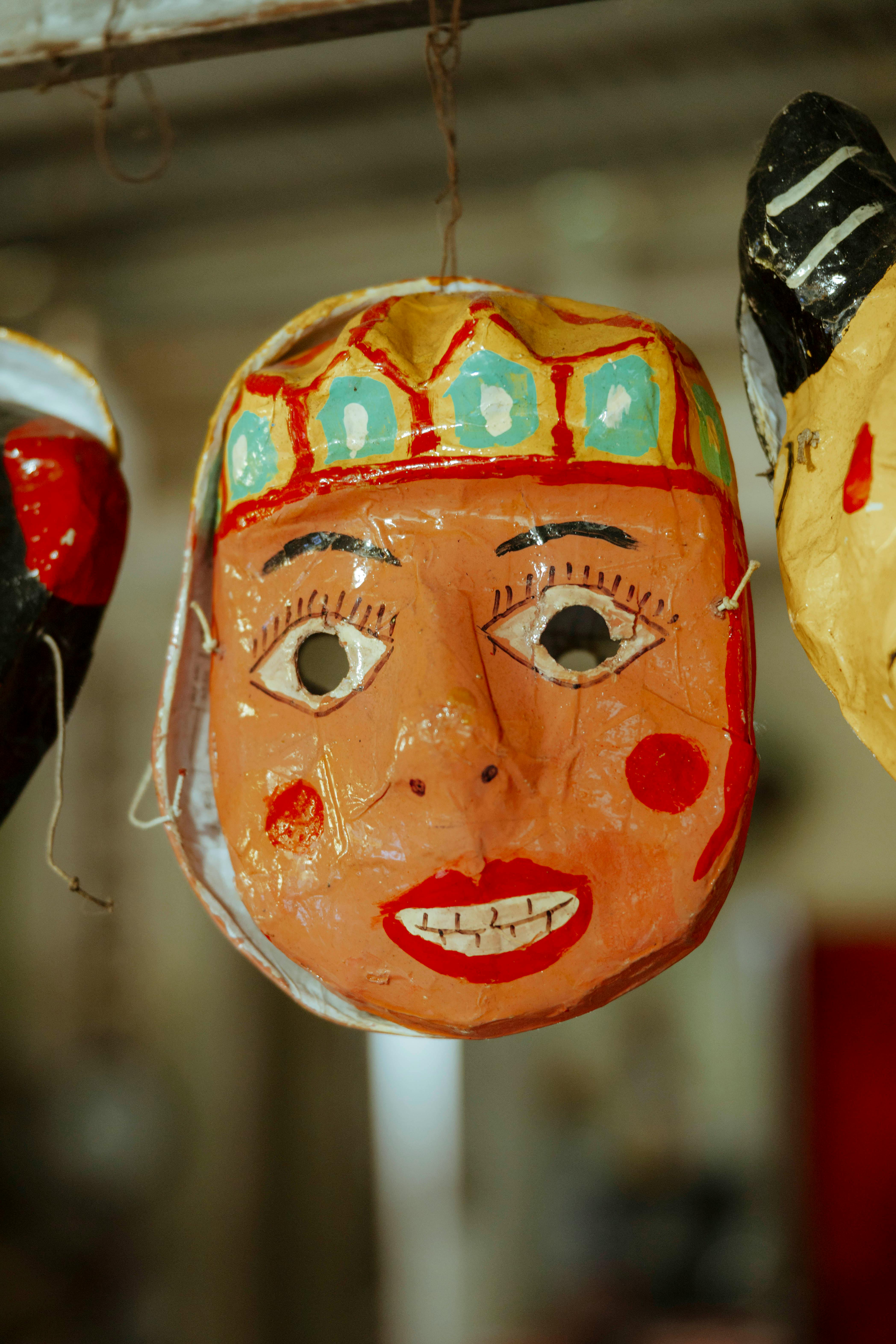 Three masks hanging from a string on a wall · Free Stock Photo
