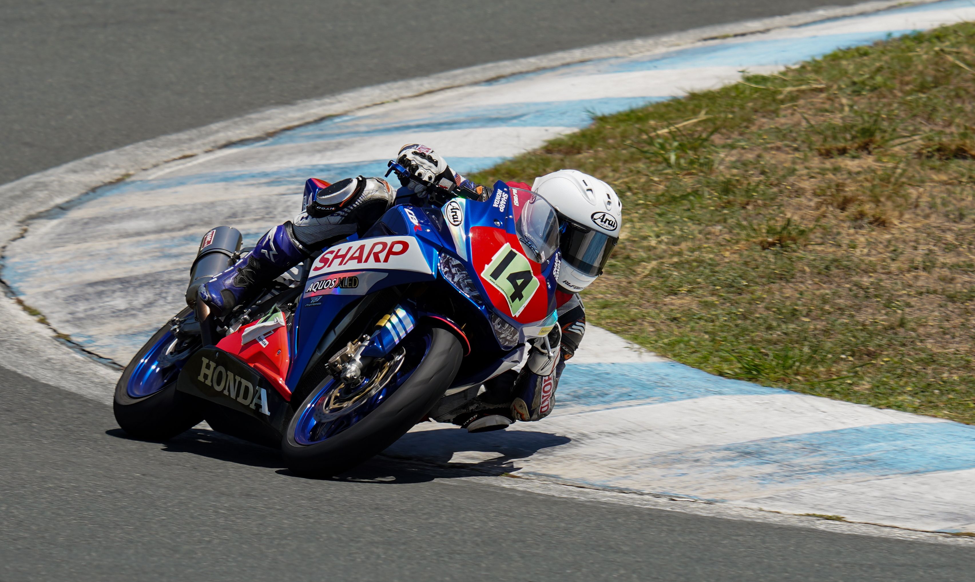 A motorcycle racer is riding down a track · Free Stock Photo