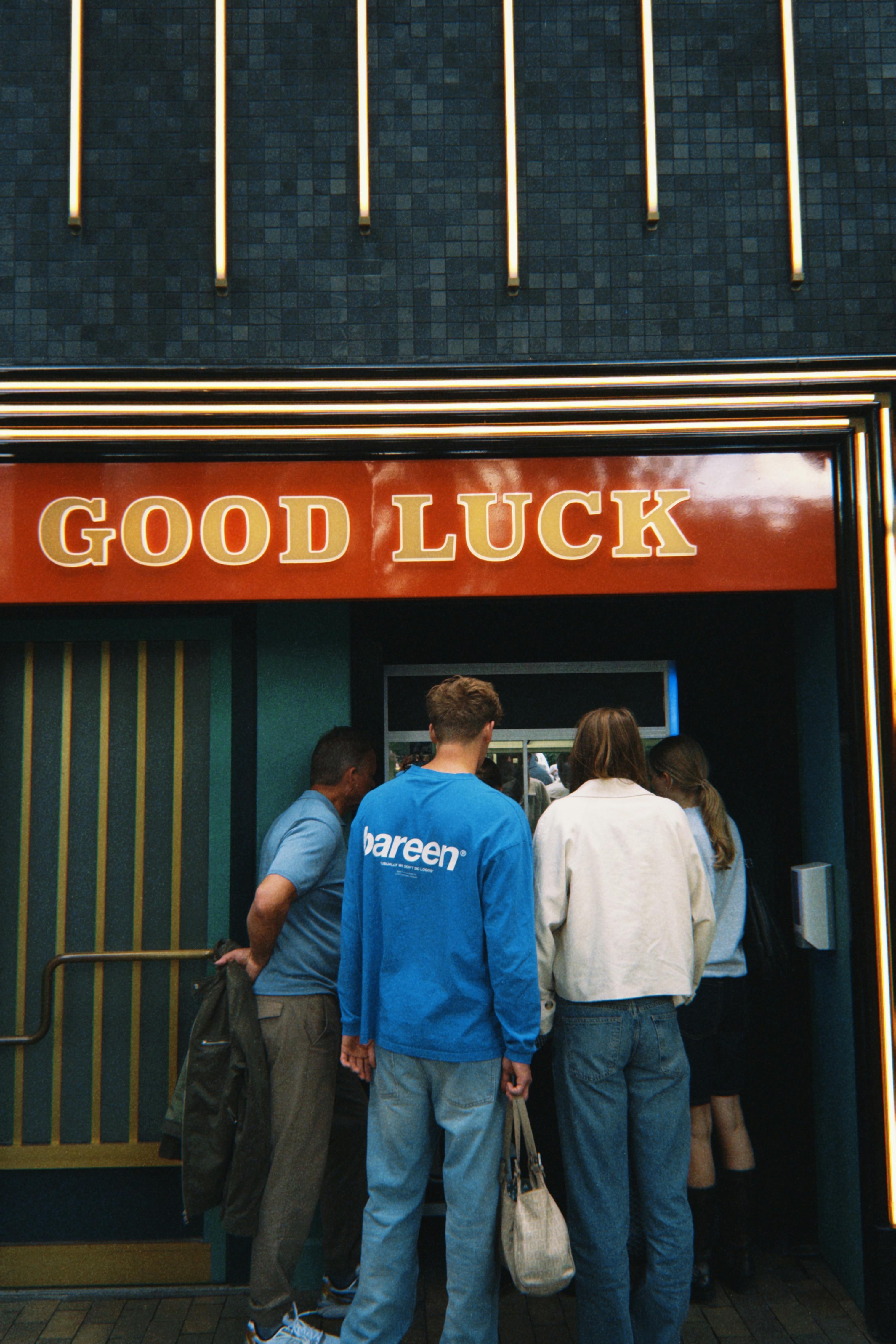People standing outside a store with the words good luck · Free Stock Photo