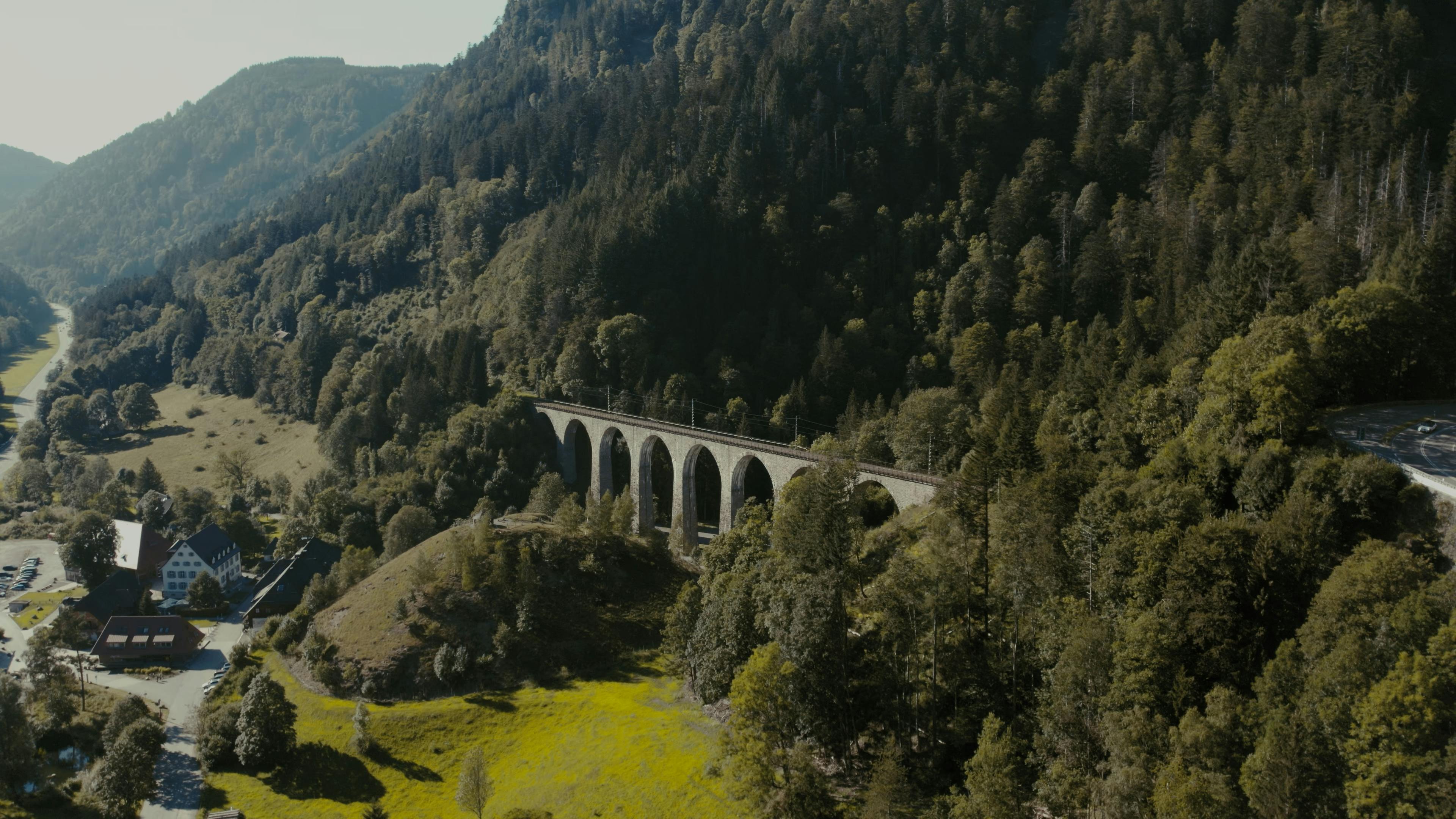 Aerial view of a train crossing a bridge over a valley · Free Stock Photo