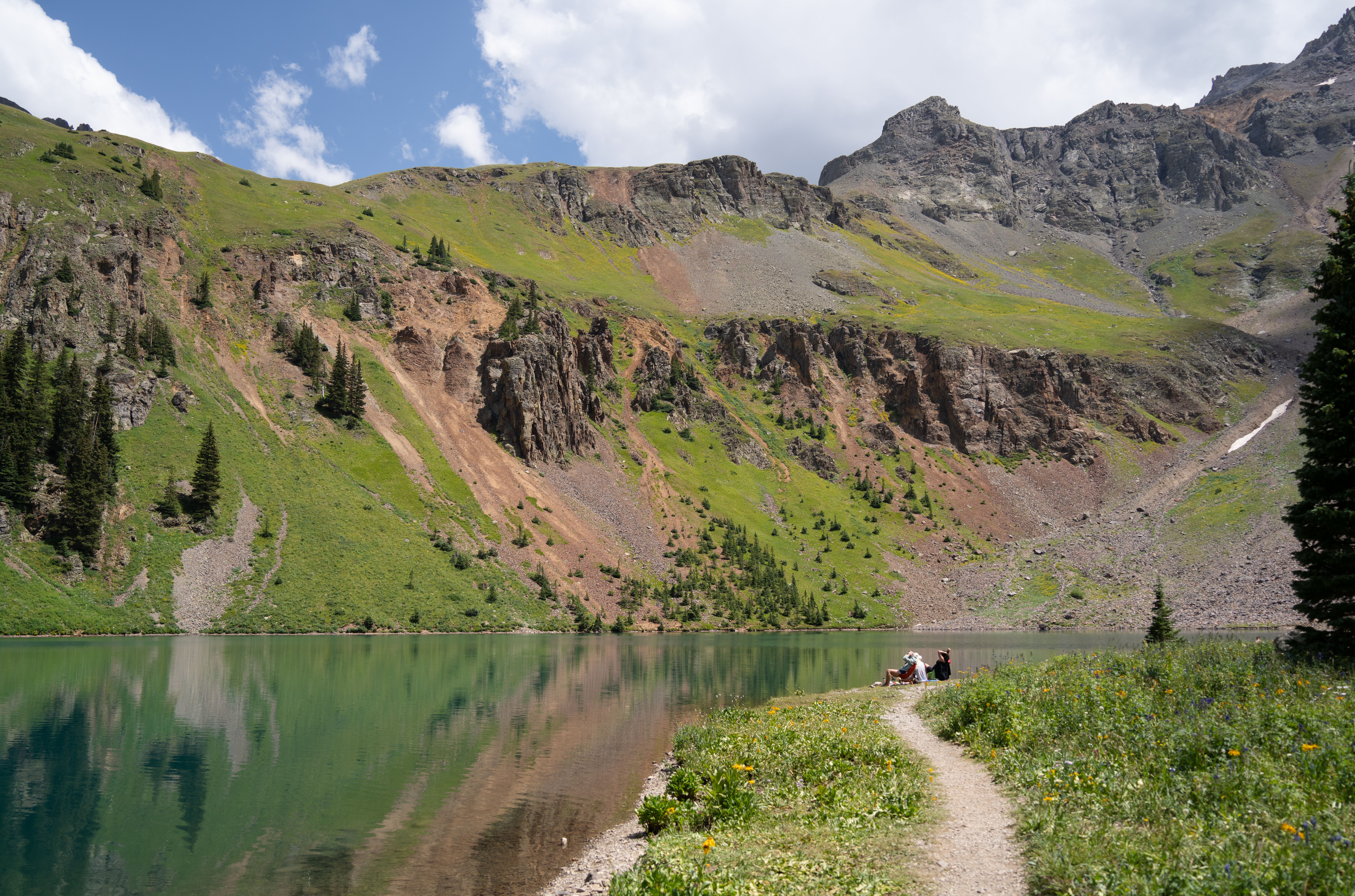 A person walking along a trail near a lake · Free Stock Photo